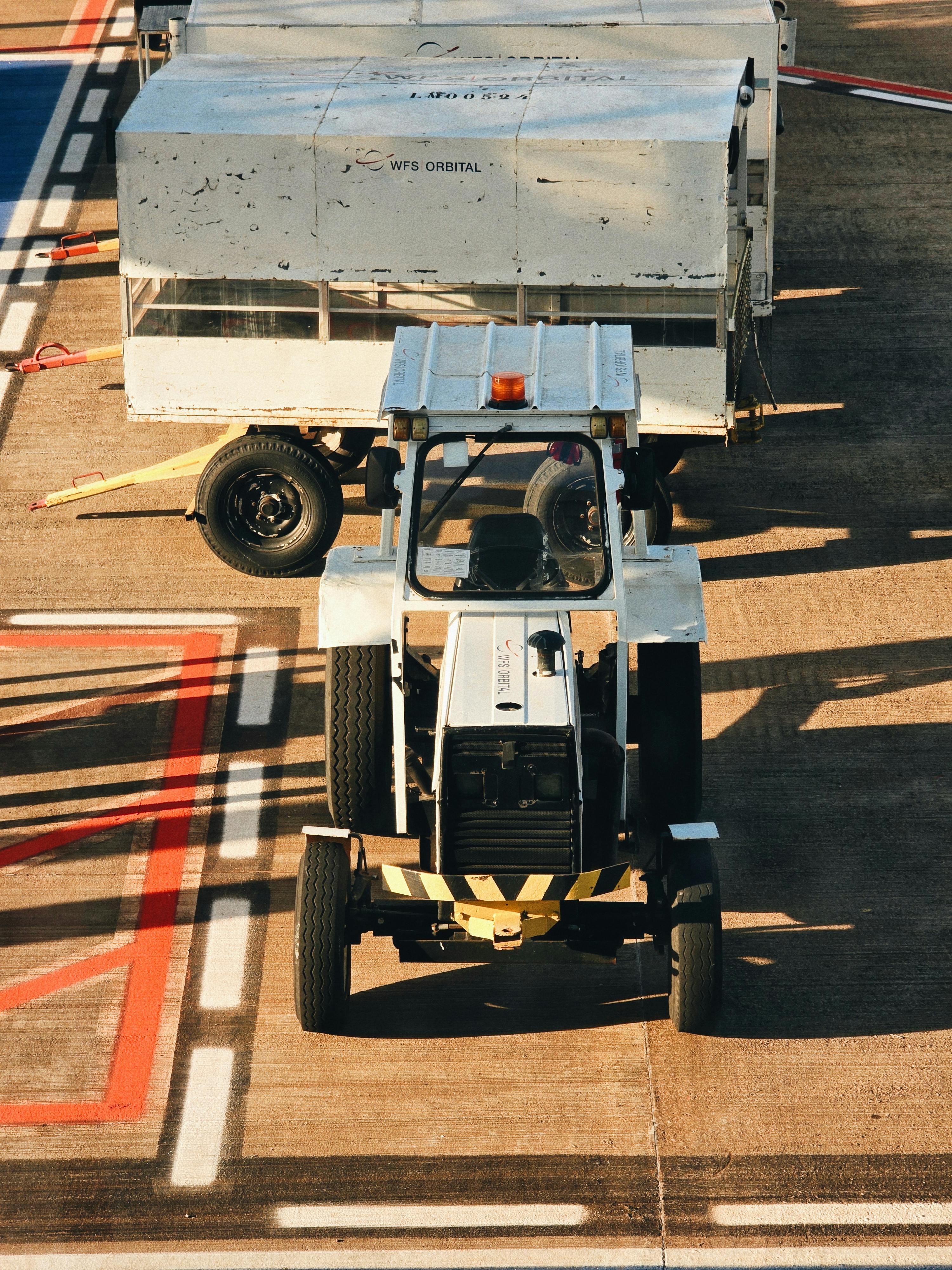 Tractor and Trailer on Airport Tarmac · Free Stock Photo