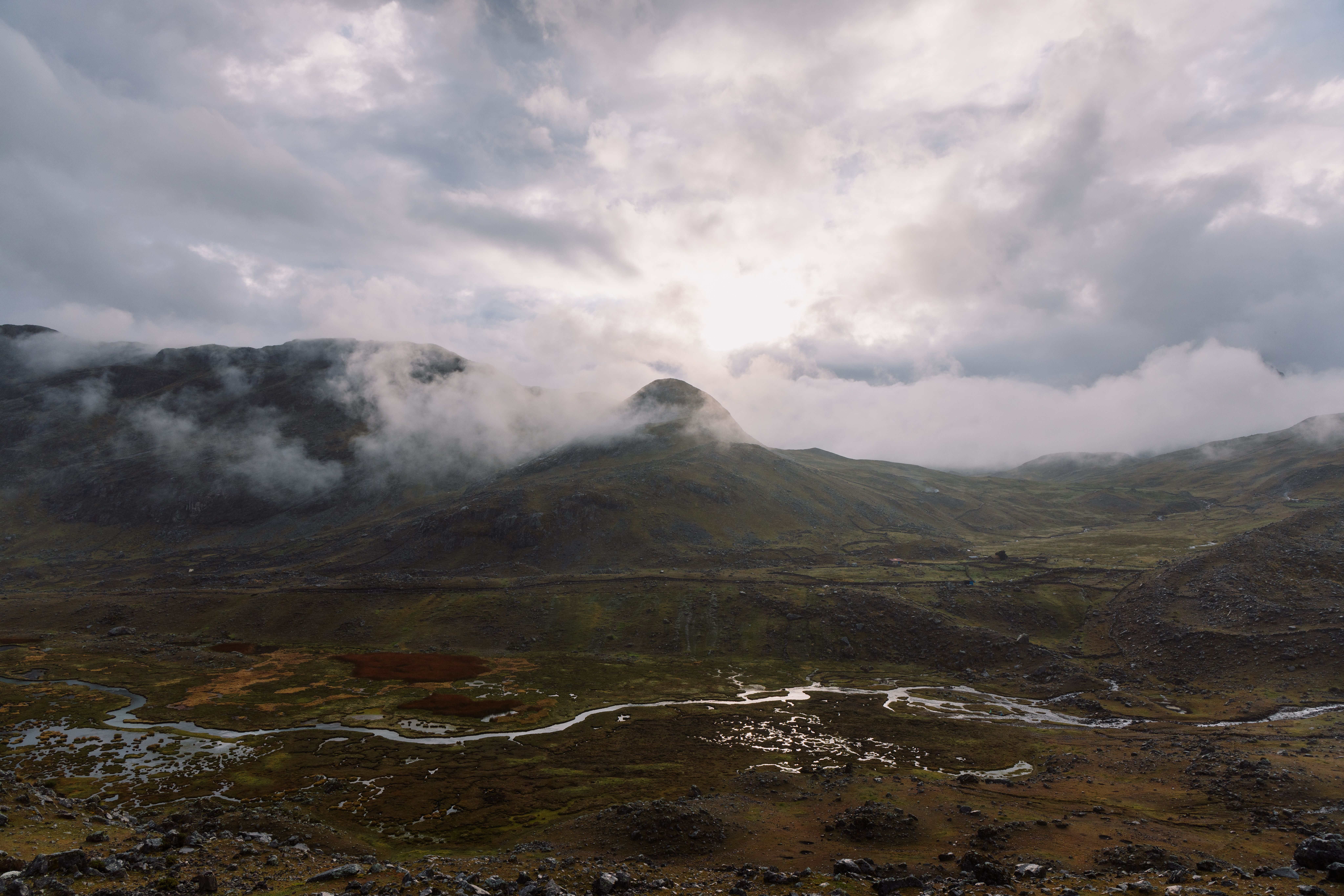 A valley with mountains and clouds in the distance · Free Stock Photo
