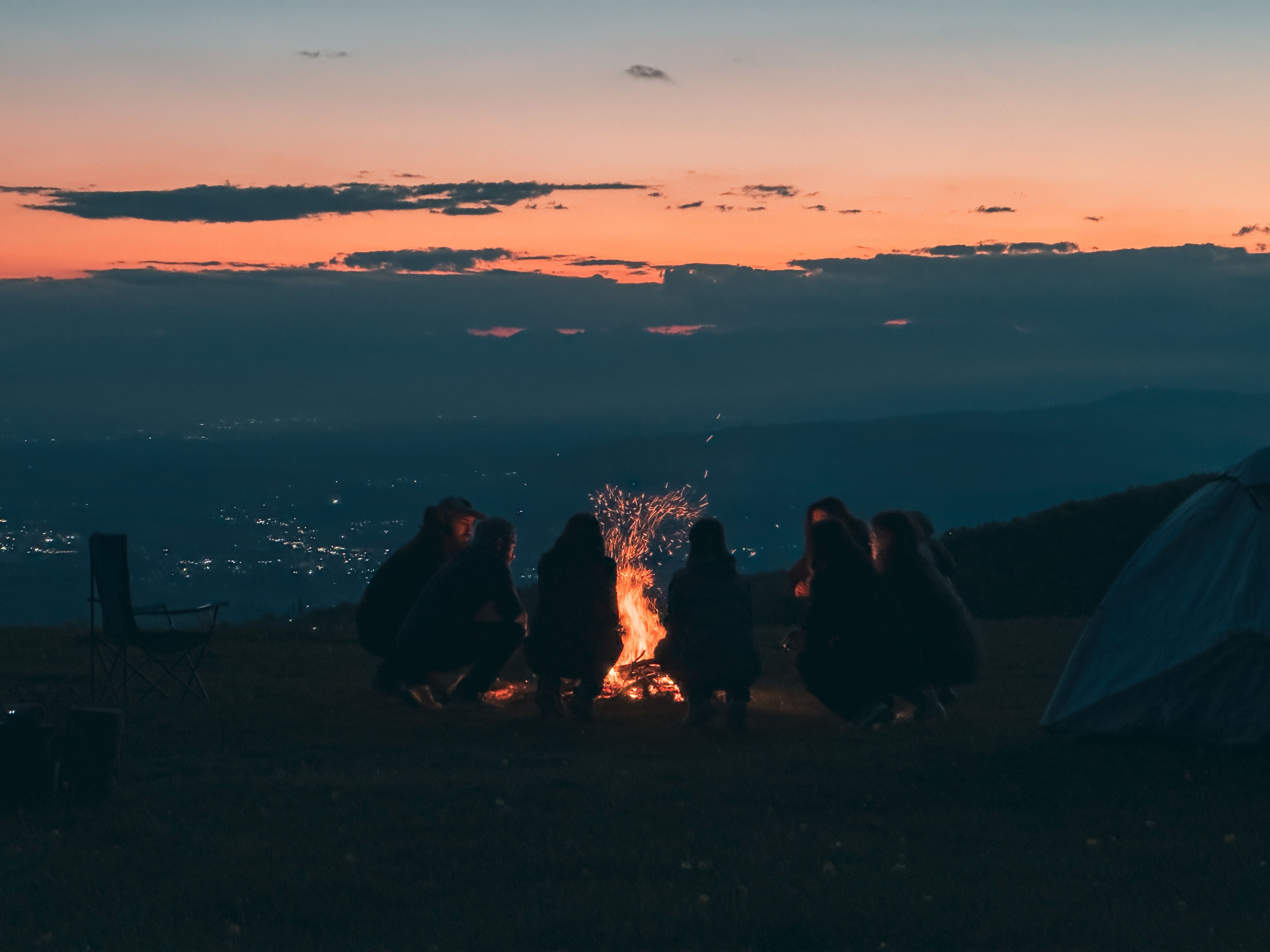 People Crouching around Campfire in the Evening · Free Stock Photo