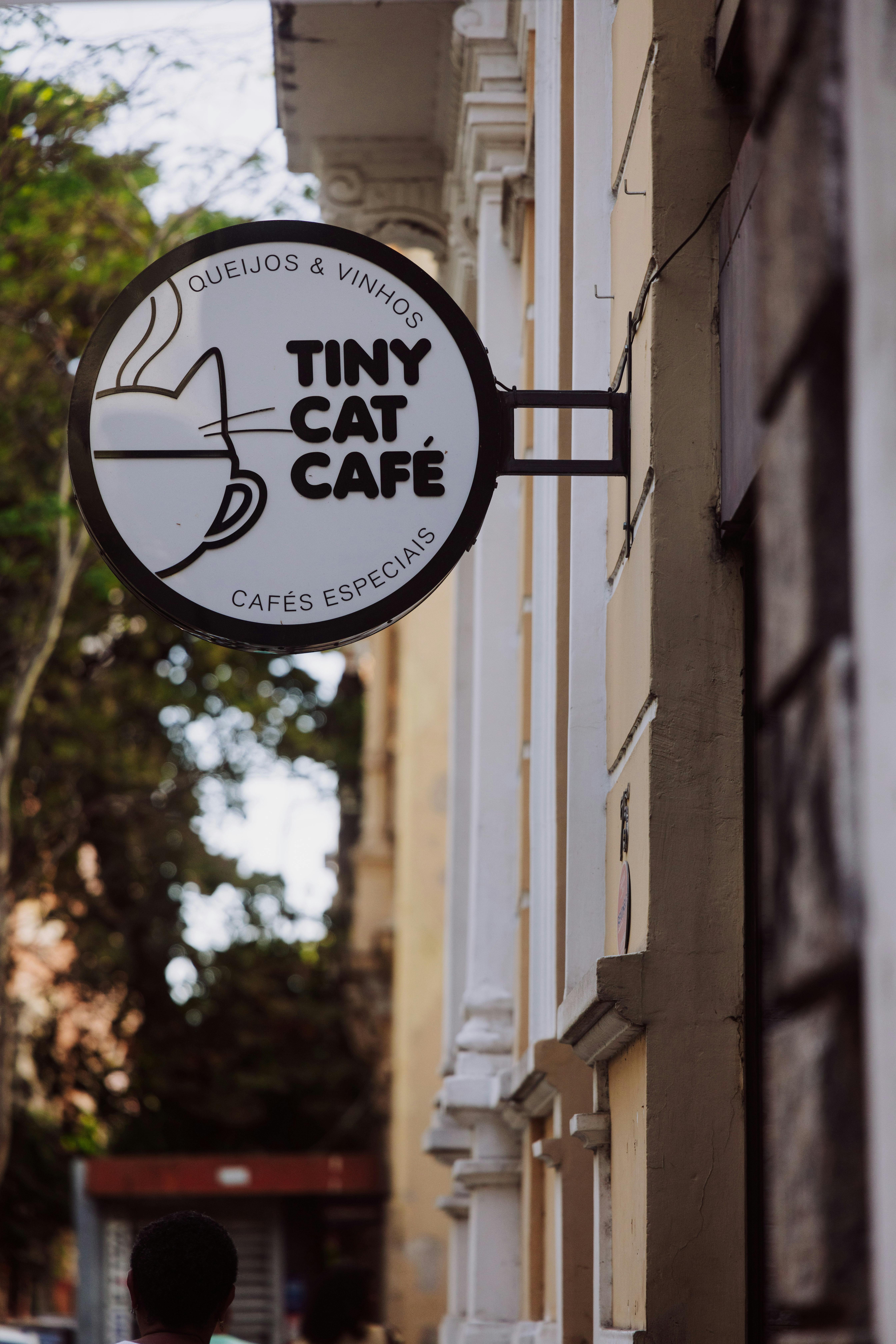 A sign for tiny coffee cafe on a building · Free Stock Photo