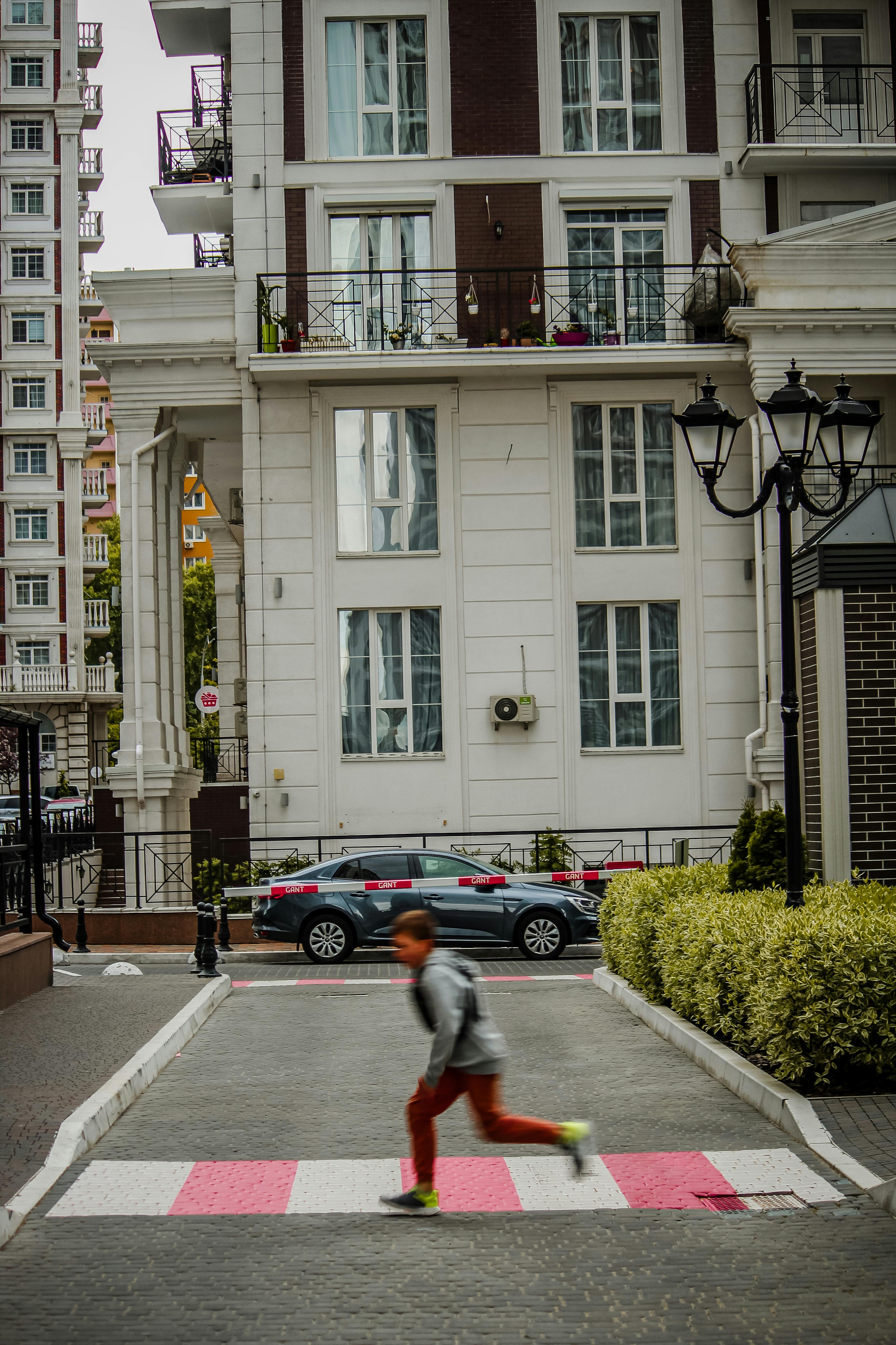 A person running across a crosswalk in front of a building · Free Stock ...