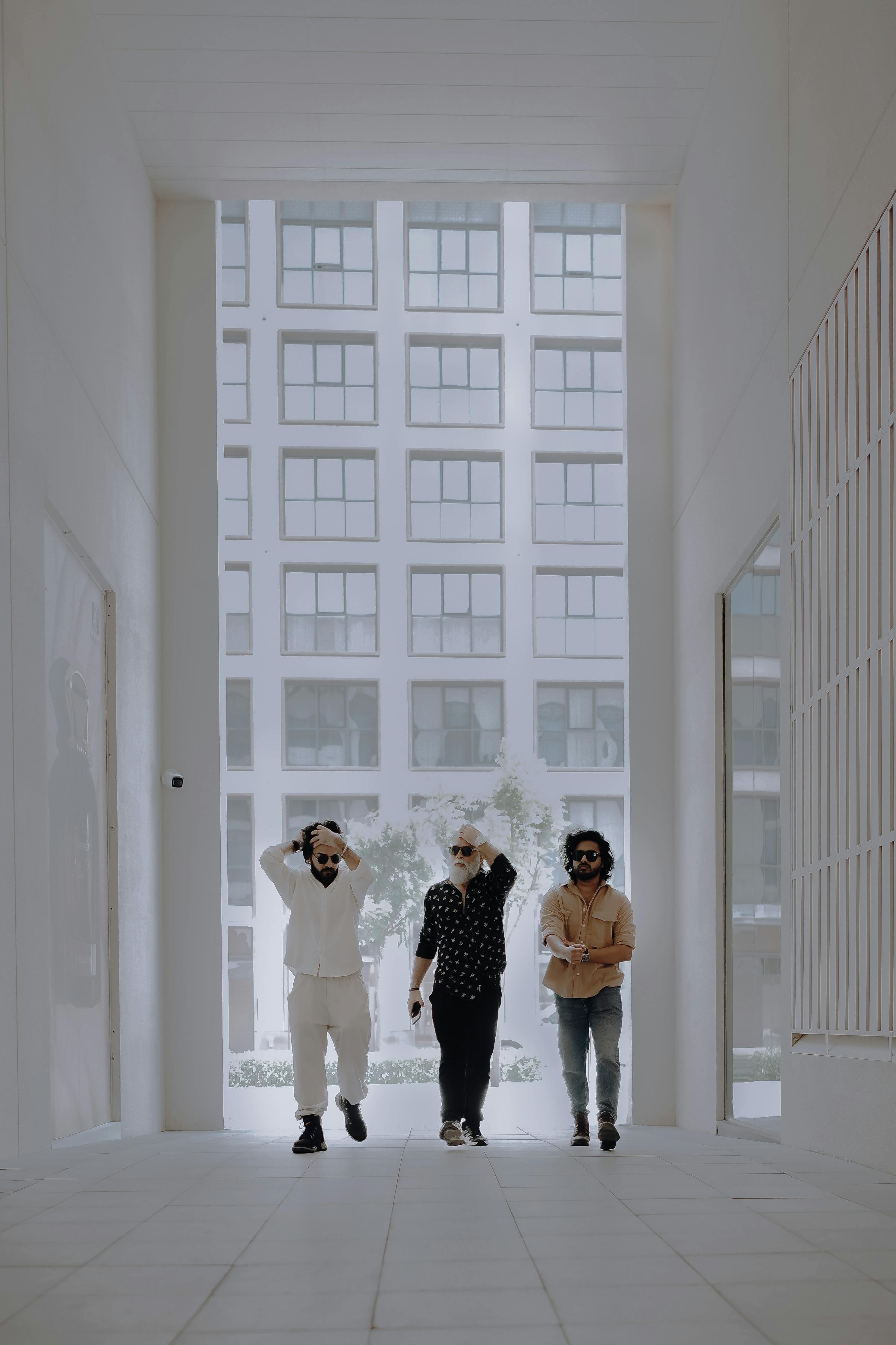 Three Men Walking into a Building · Free Stock Photo