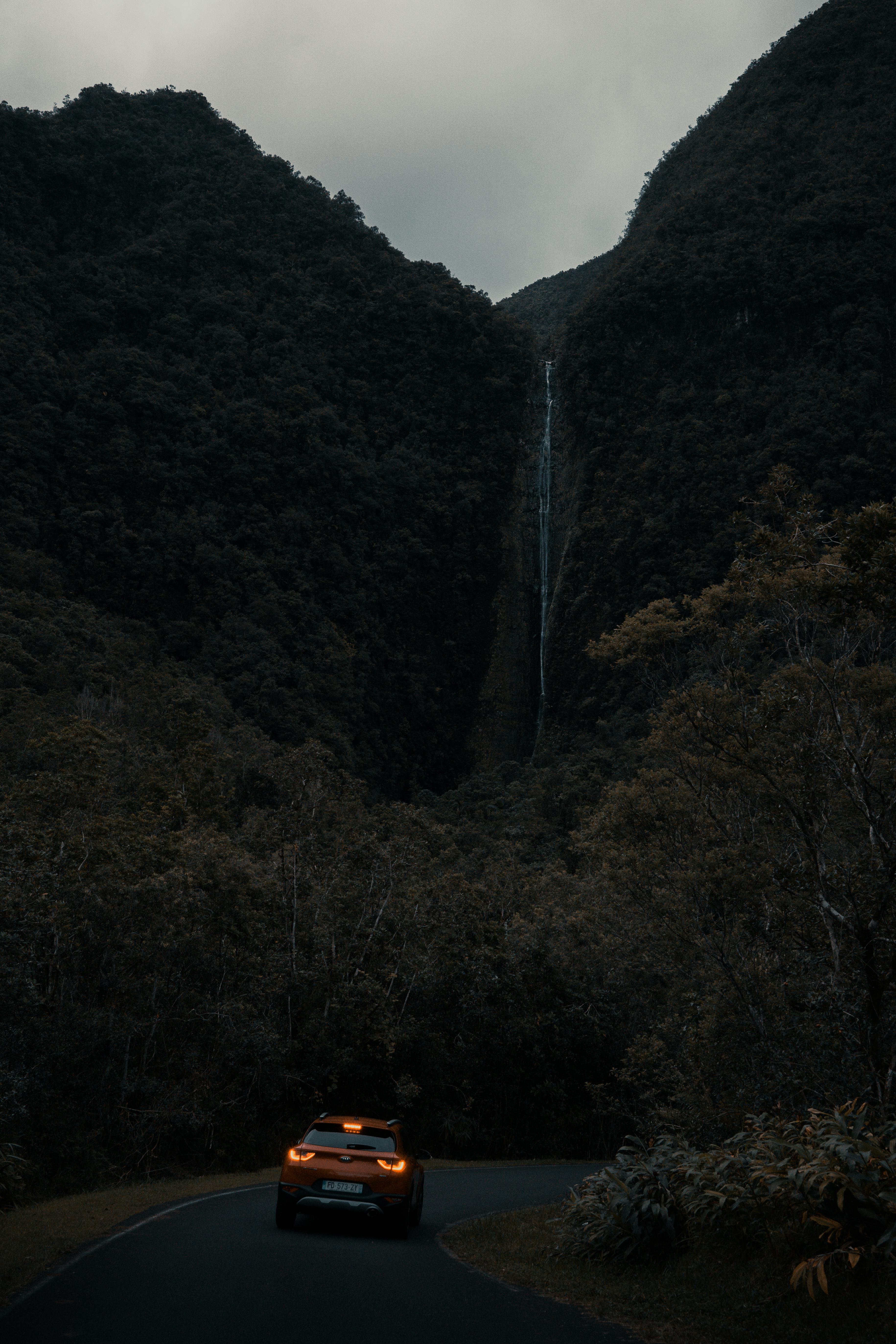 Orange Car Across Waterfalls Photo · Free Stock Photo