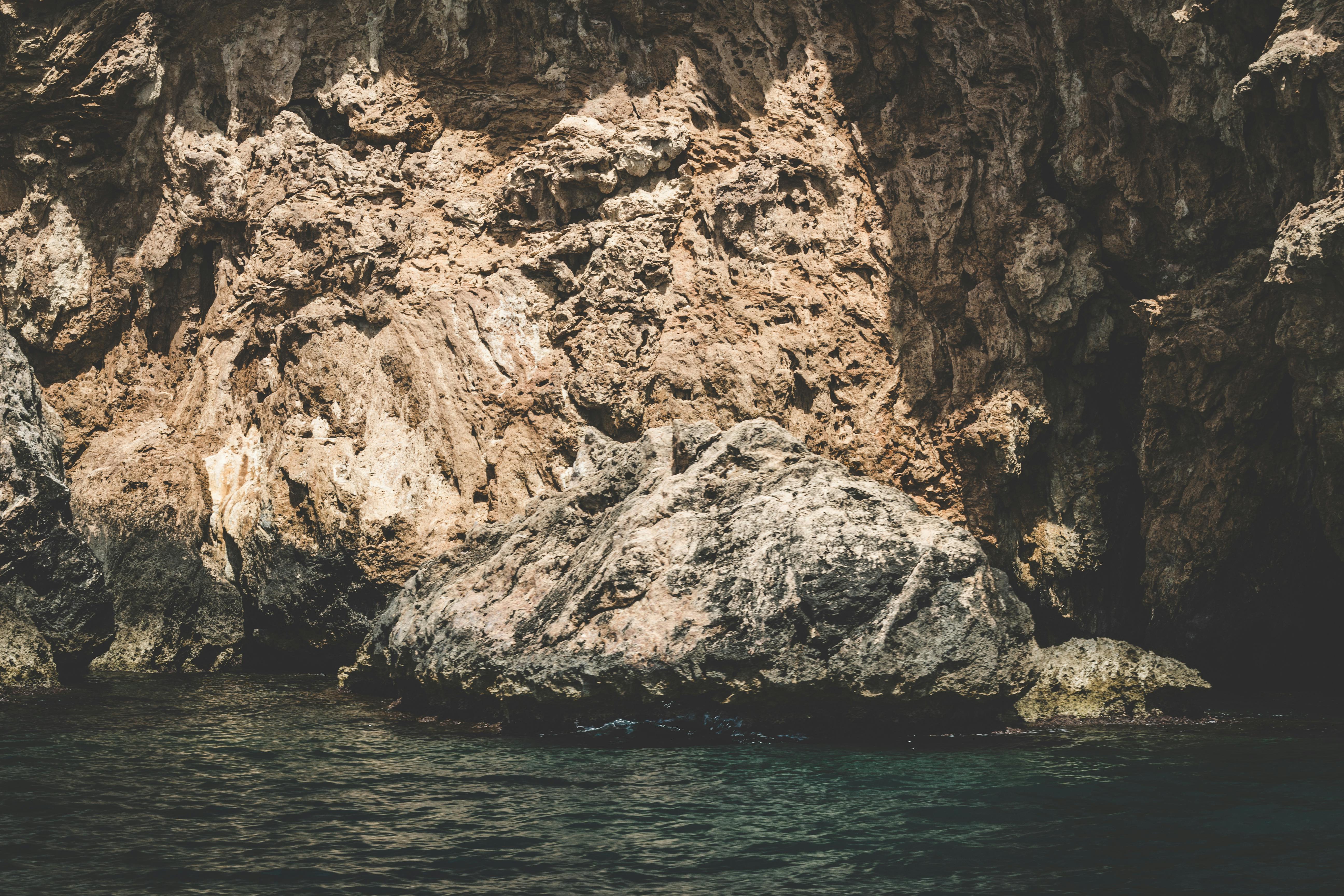 Brown Rock Near Body of Water · Free Stock Photo