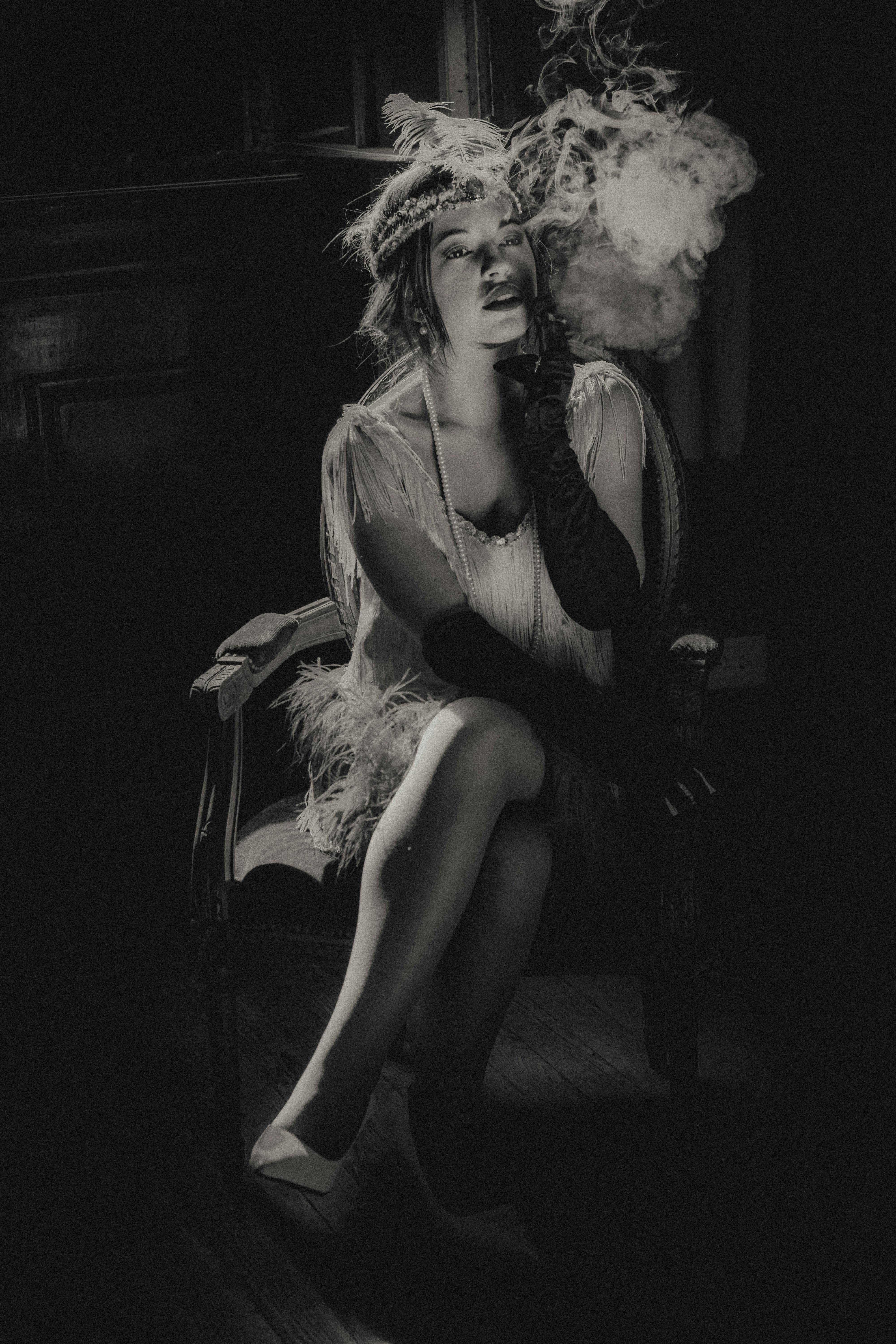 Woman Sitting in Flapper Dress and Smoking Cigarette · Free Stock Photo