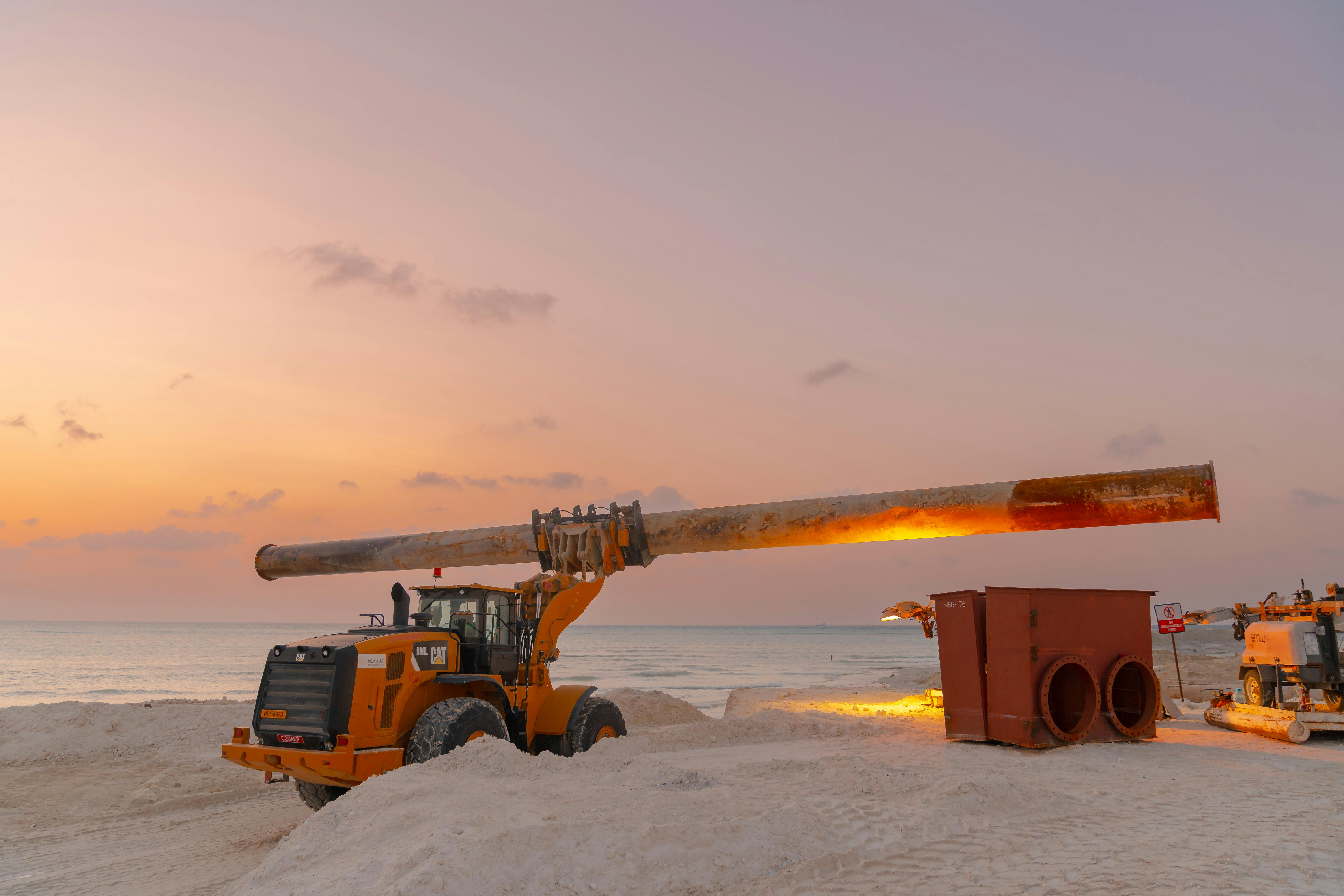 A construction vehicle is working on a beach · Free Stock Photo