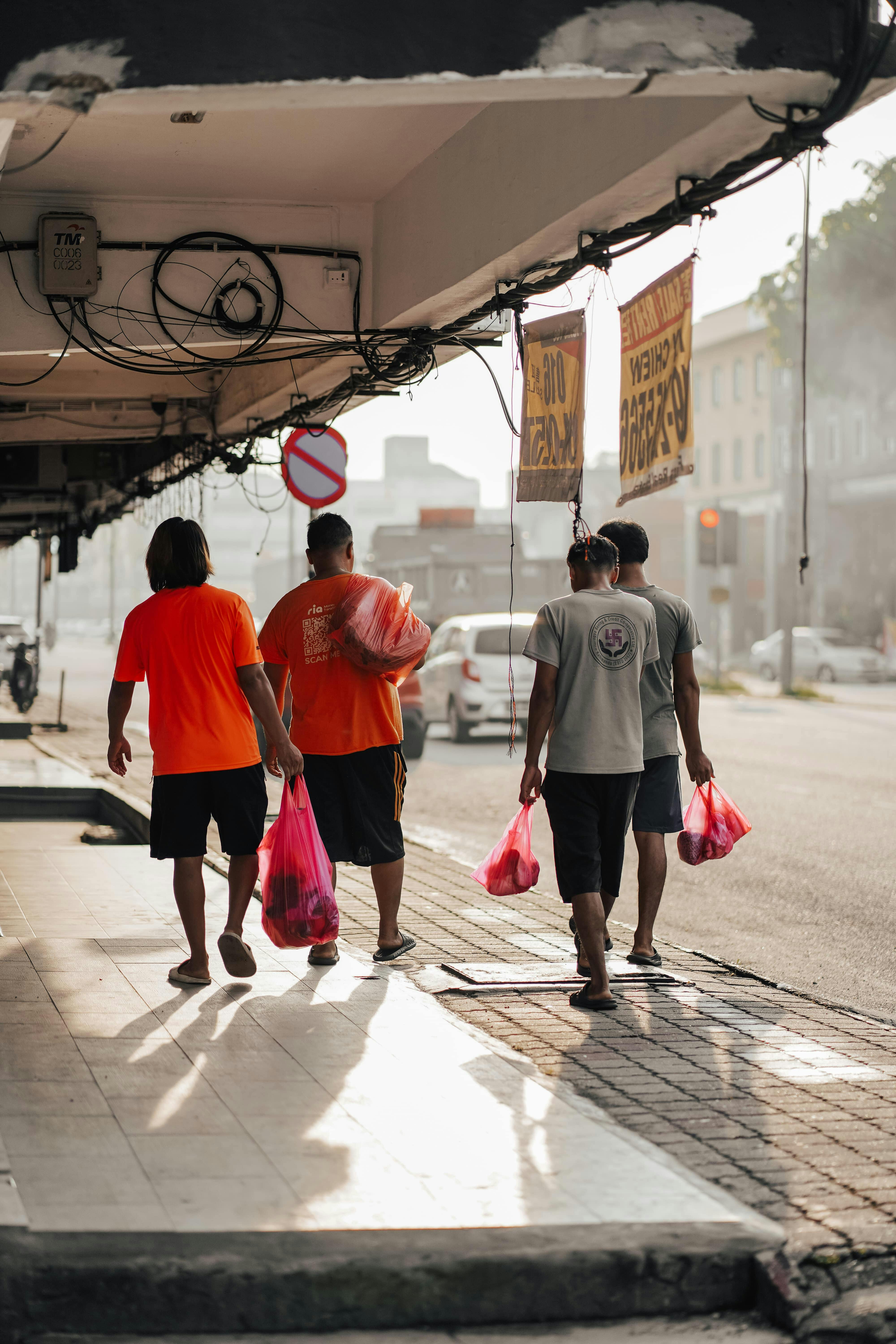 Back View of Pedestrians Walking on a Sidewalk · Free Stock Photo