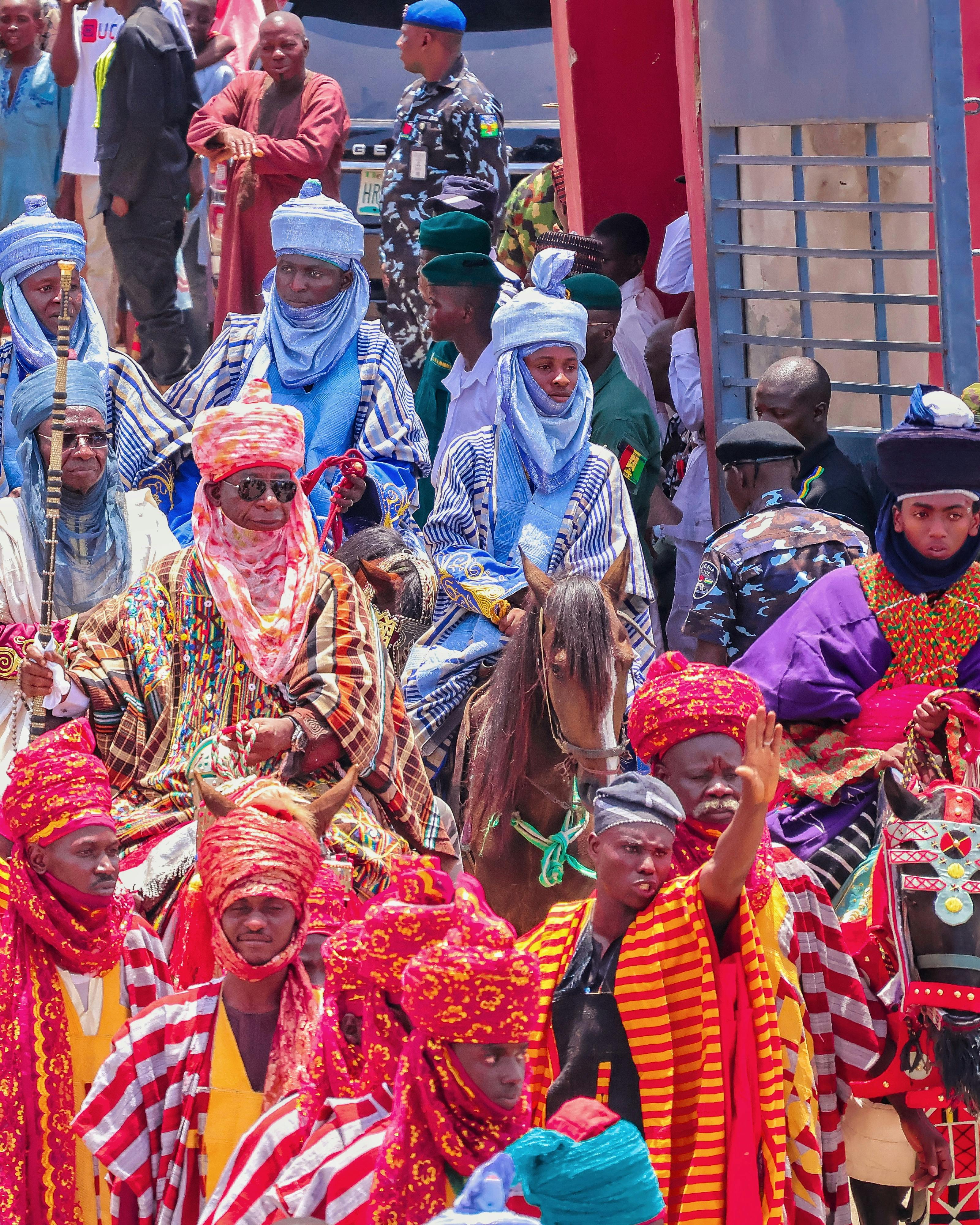 Photo of a Group of People in Traditional Clothing Walking on a Street ...