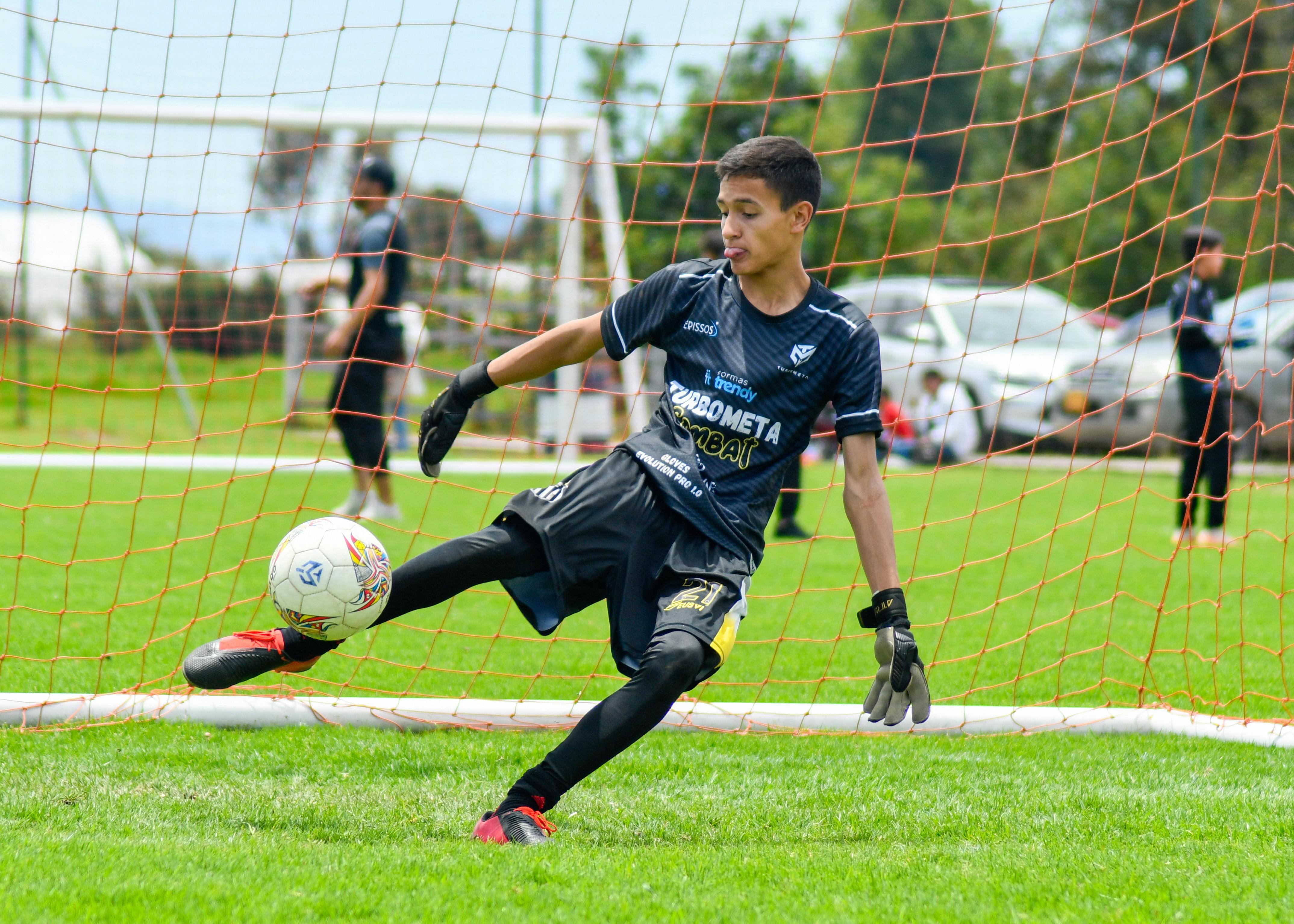Young Goalkeeper Kicking a Soccer Ball during a Match · Free Stock Photo