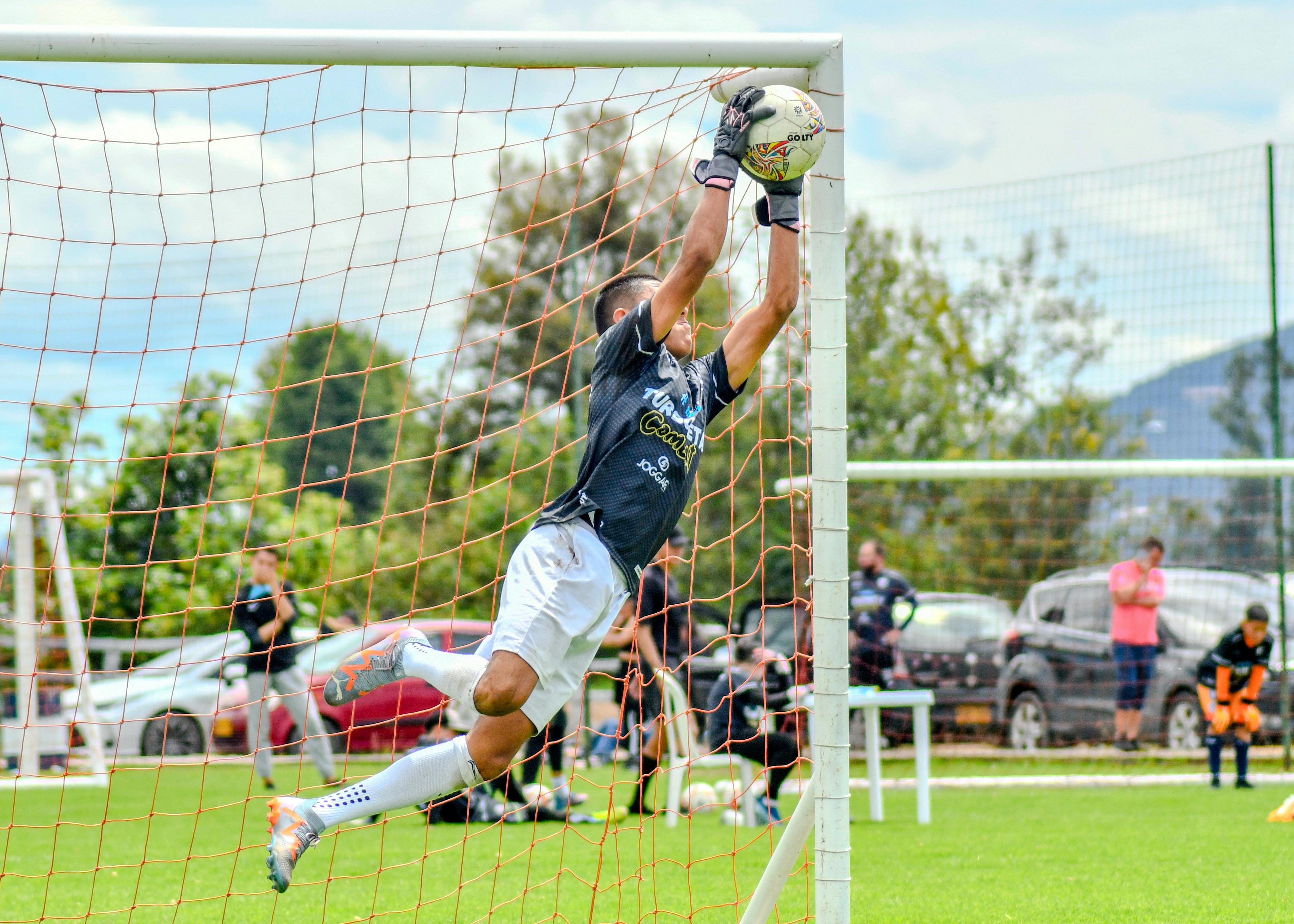 Goalkeeper Jumping to Catch the Ball · Free Stock Photo