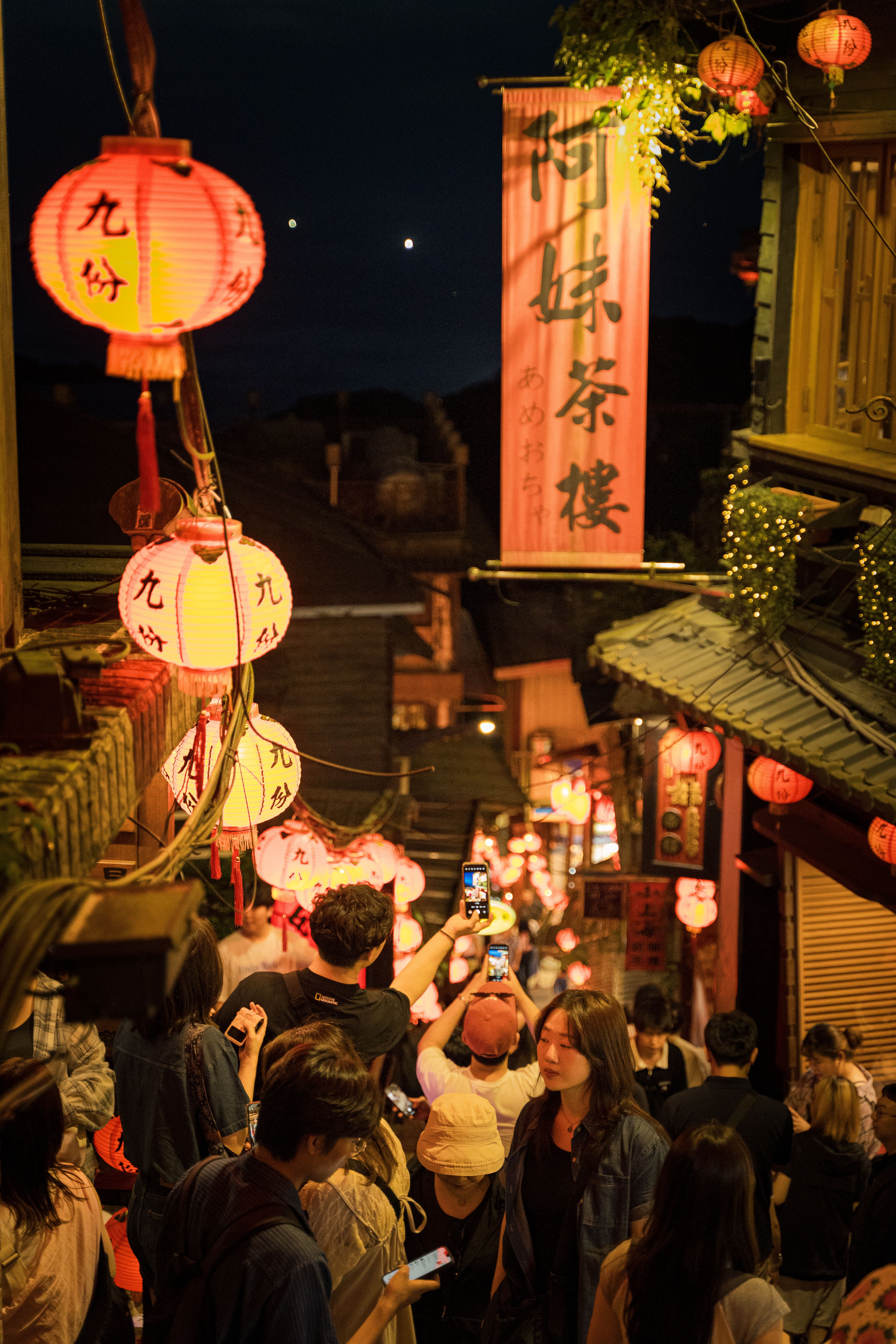 Pedestrians Walking on a Street Illuminated with Red Lanterns at Night ...