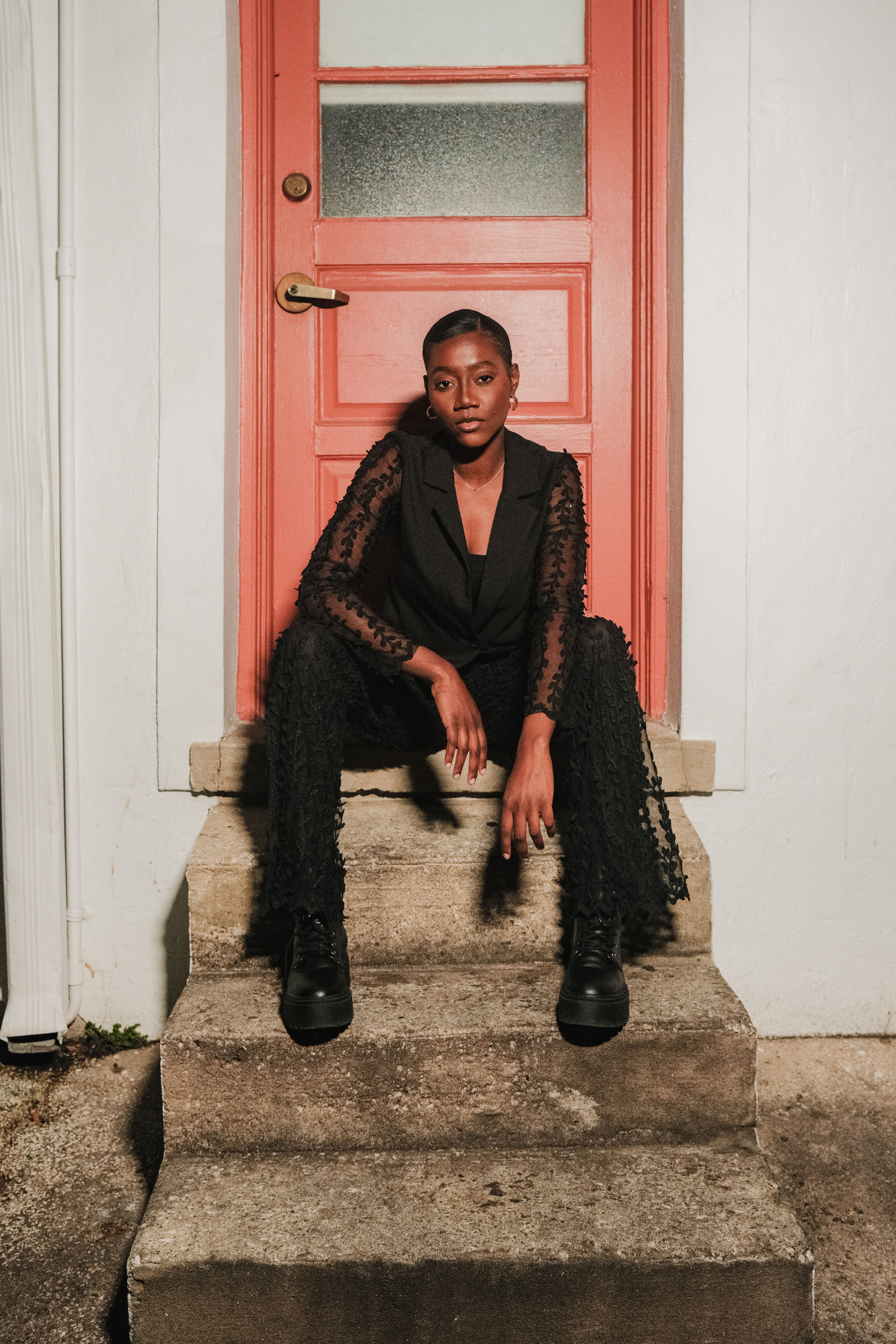 A Fashionable Woman Sitting on Steps by the Front Door · Free Stock Photo