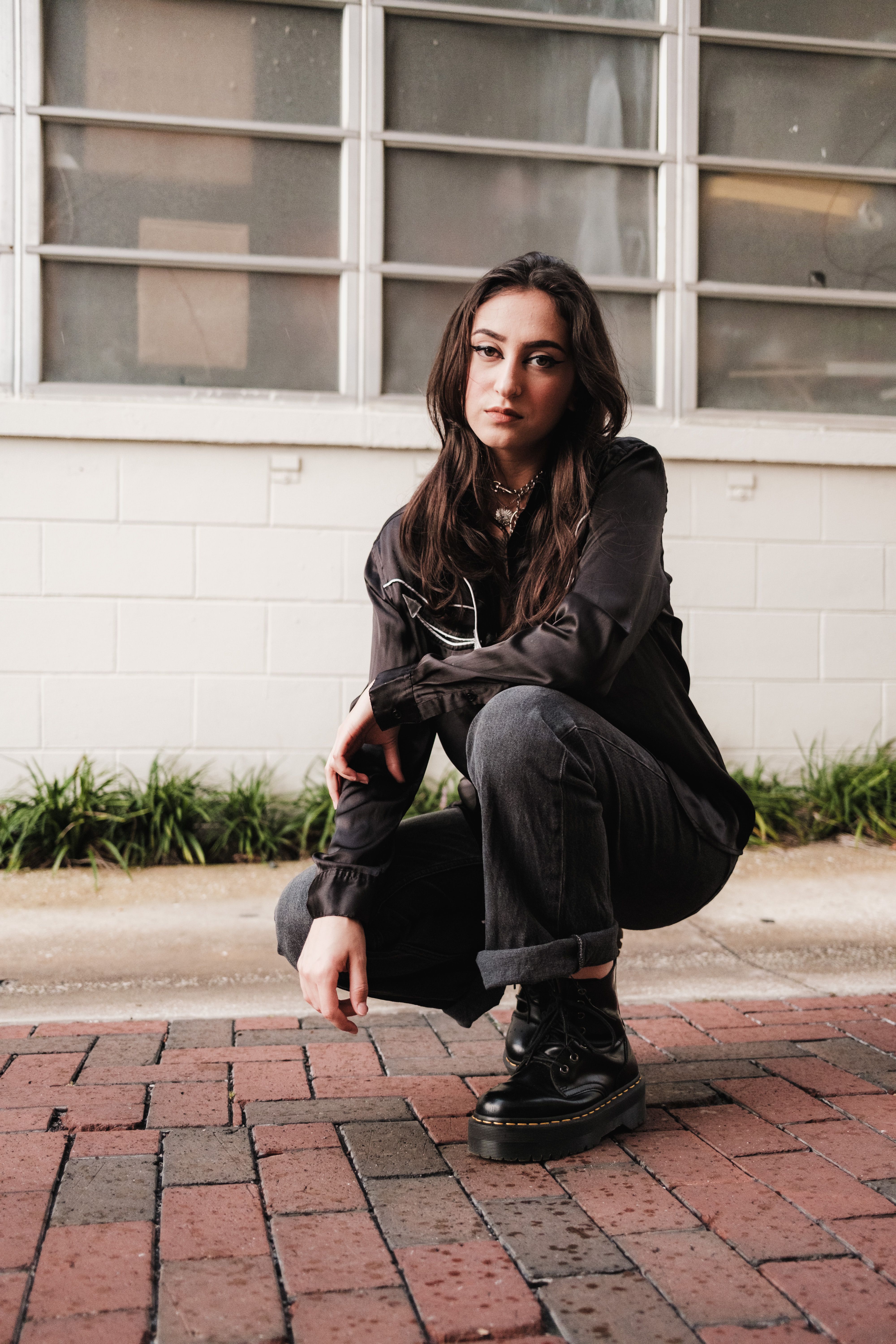 Woman in Black Jacket Crouching on Sidewalk · Free Stock Photo
