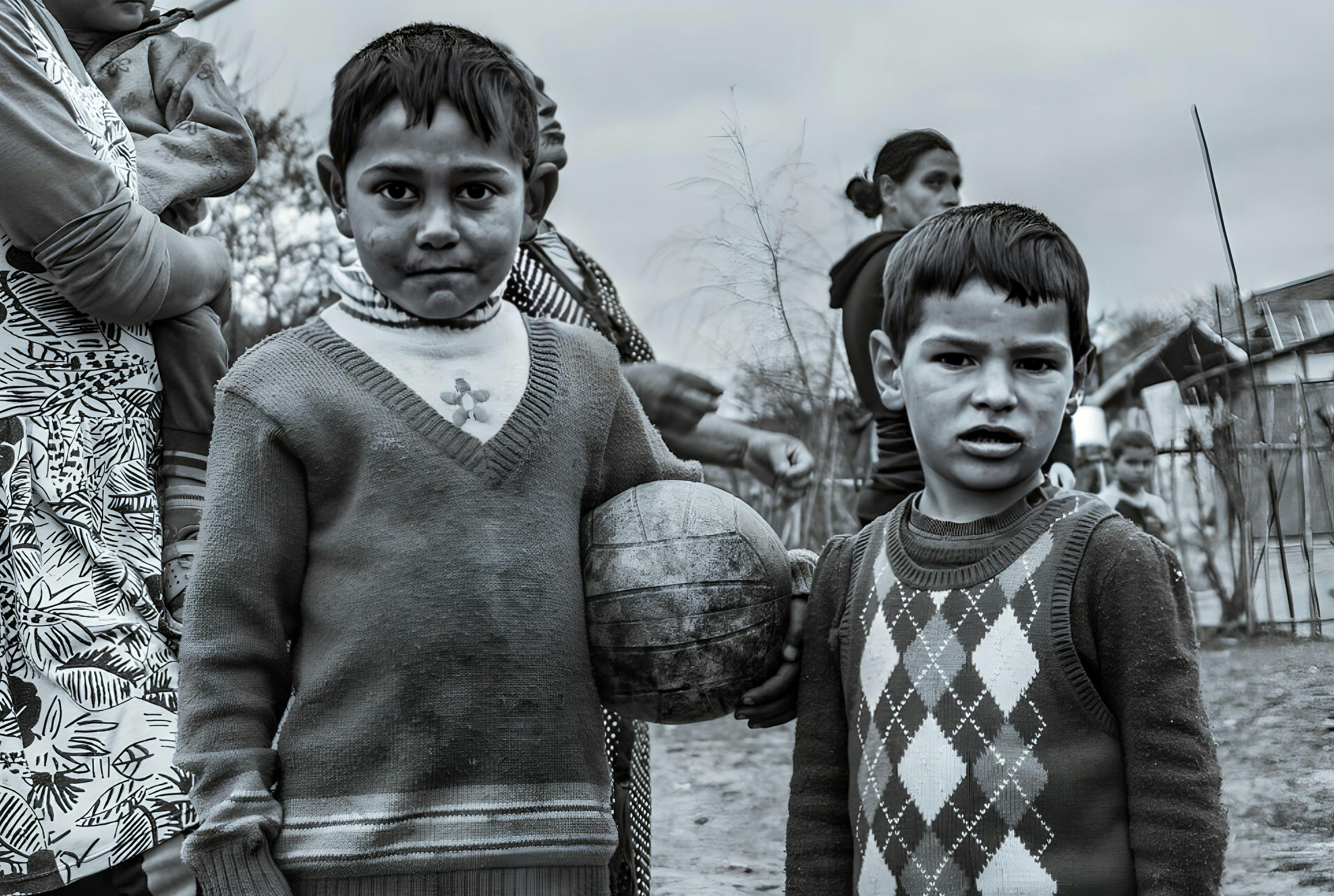 Two boys stand next to each other holding a ball · Free Stock Photo