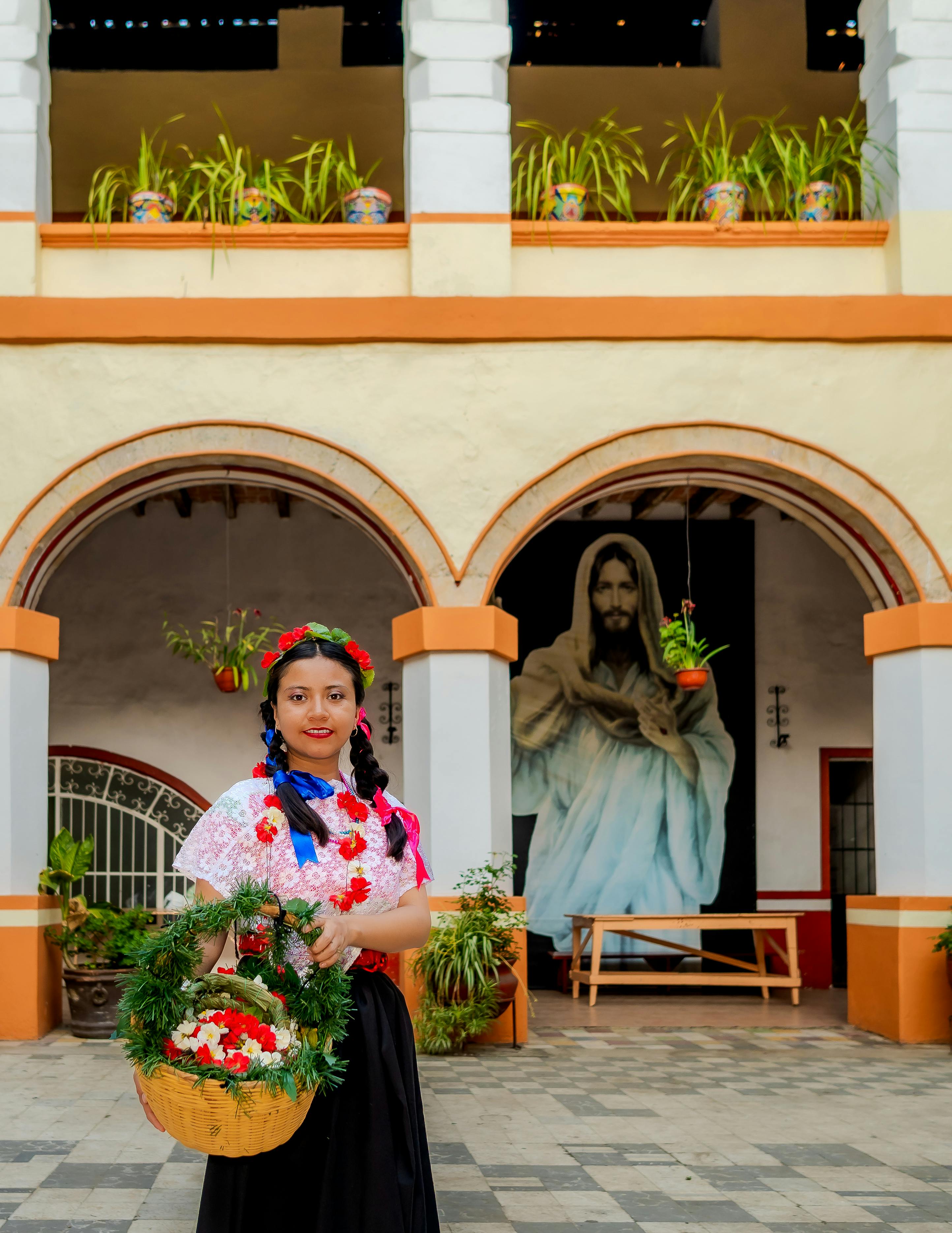 Model in a White Poncho and a Black Skirt Standing in the Courtyard ...