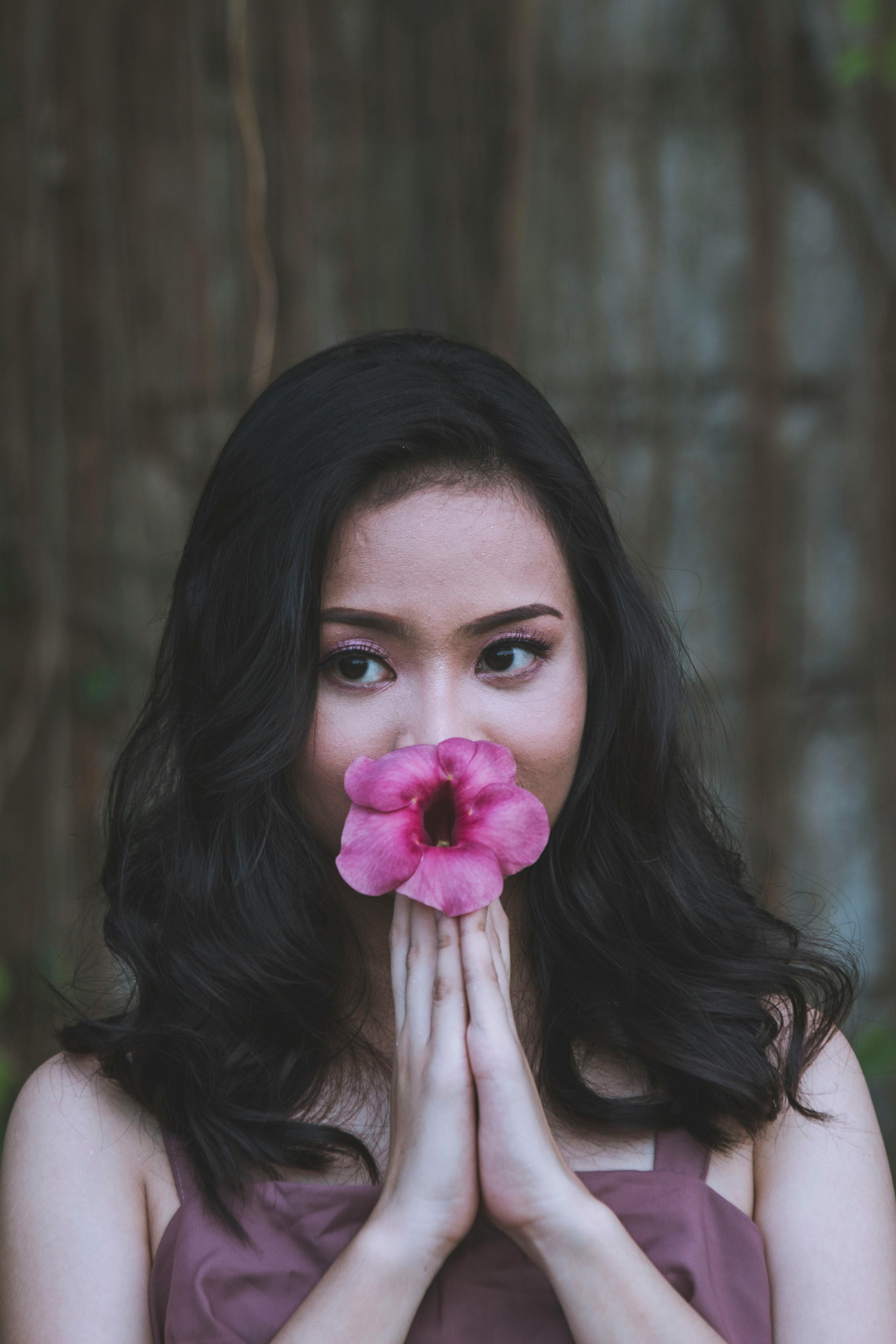 Woman Holding a Pink Hibiscus Flower · Free Stock Photo