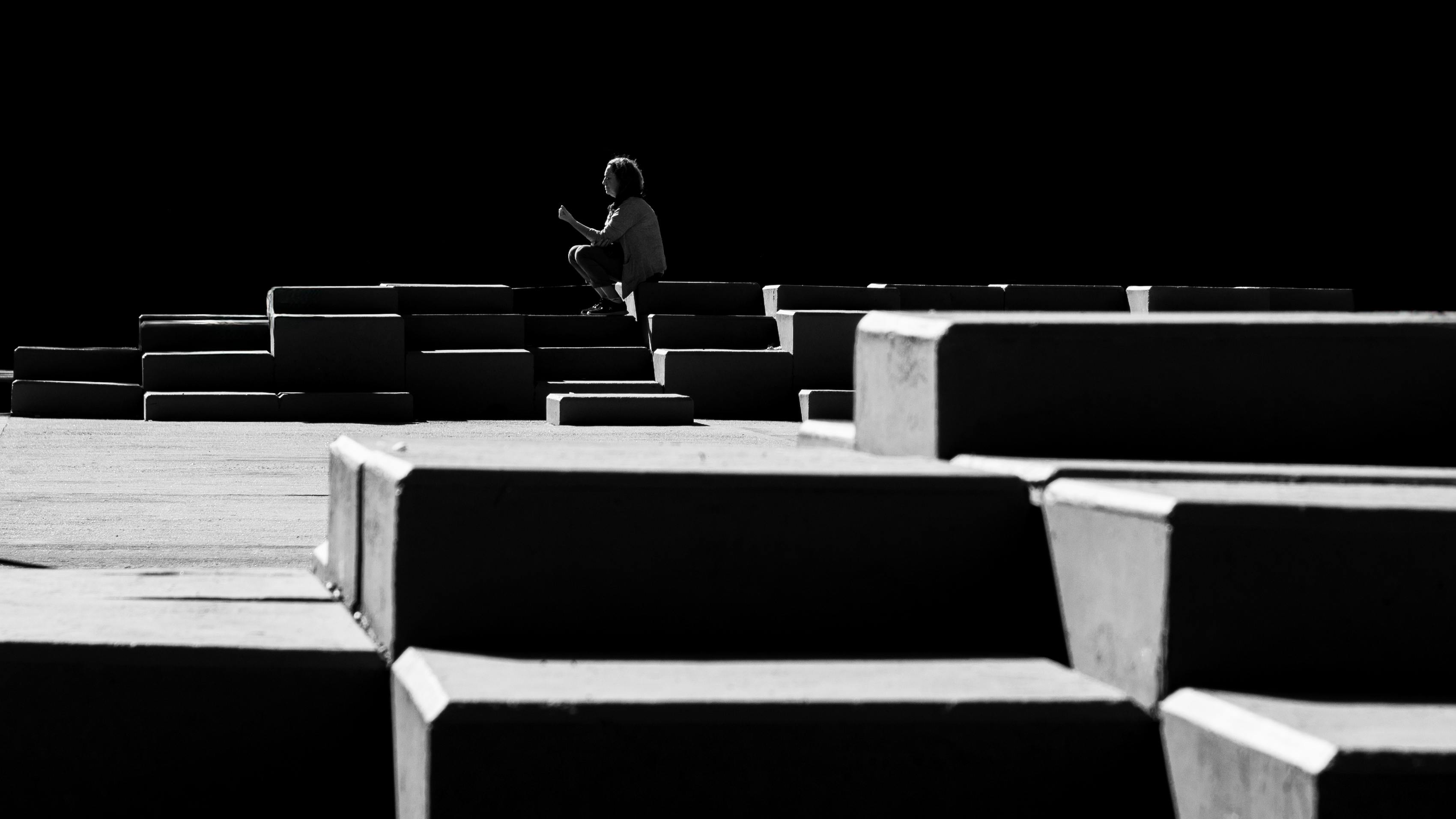 Man Sitting on Square in Black and White · Free Stock Photo
