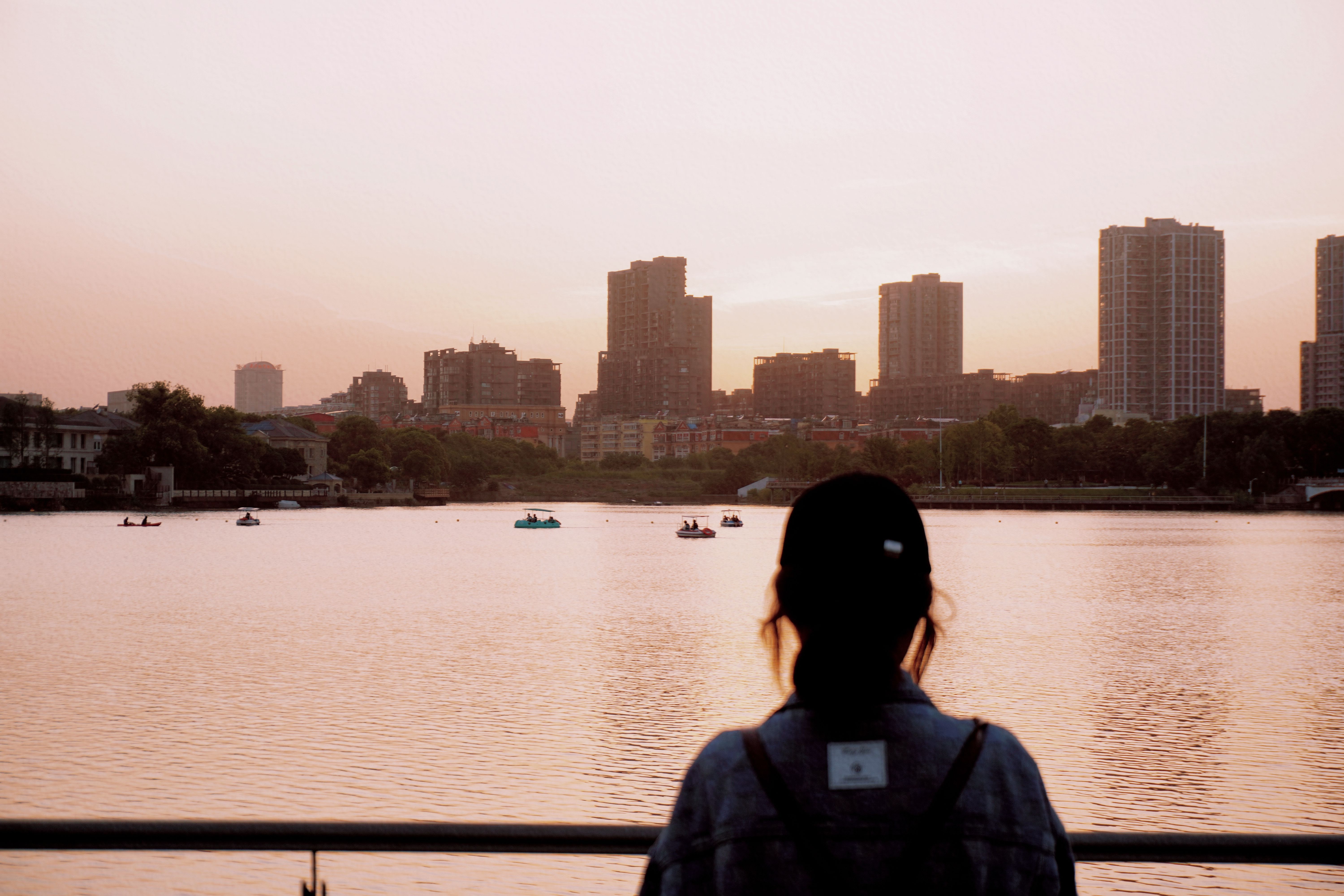 Lake and City Skyscrapers behind Woman at Sunset · Free Stock Photo
