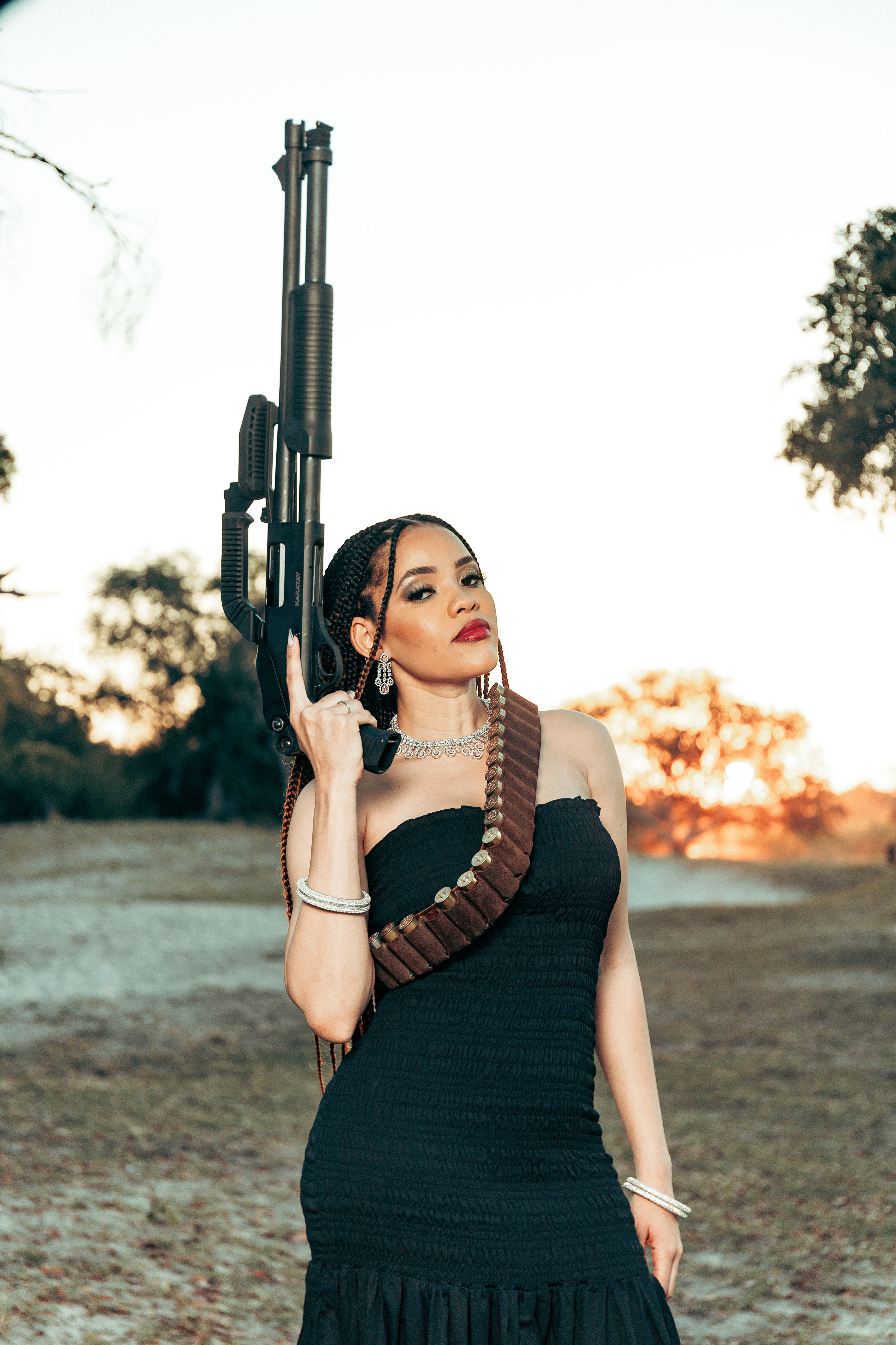 A woman in a black dress holding a gun · Free Stock Photo