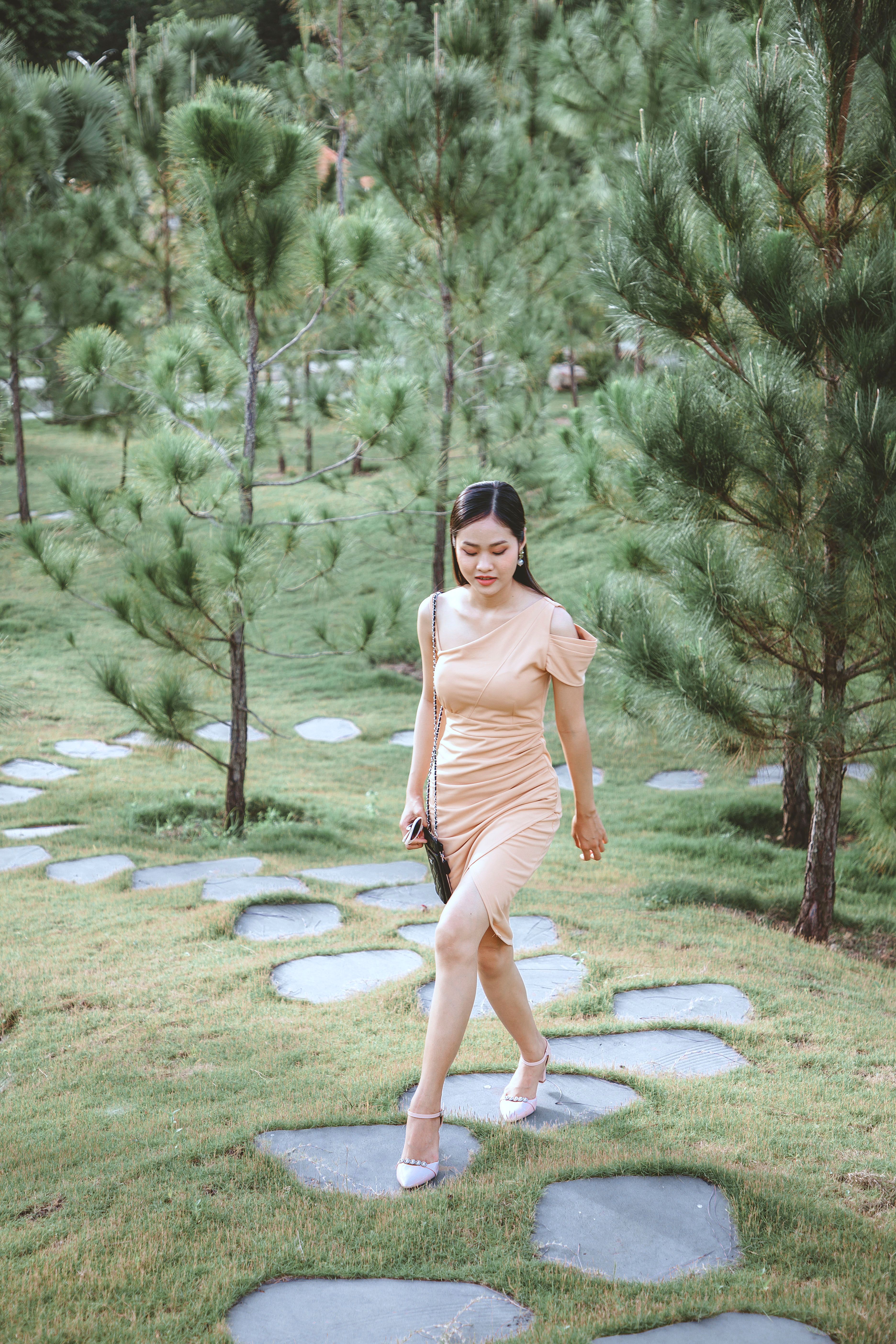Beautiful Woman in an Elegant Dress Walking on the Stones Through the ...