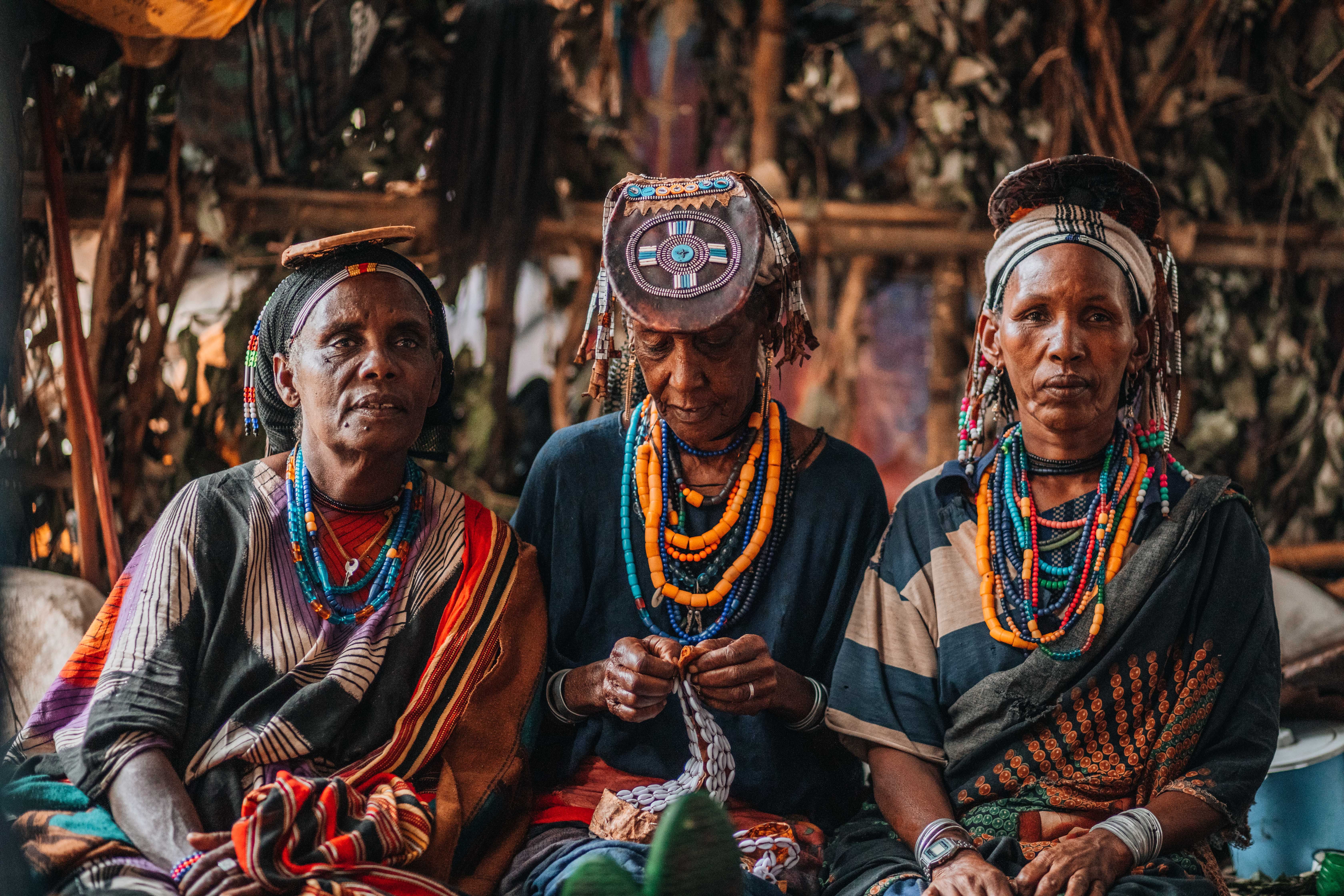 Three women wearing traditional clothing sit together · Free Stock Photo