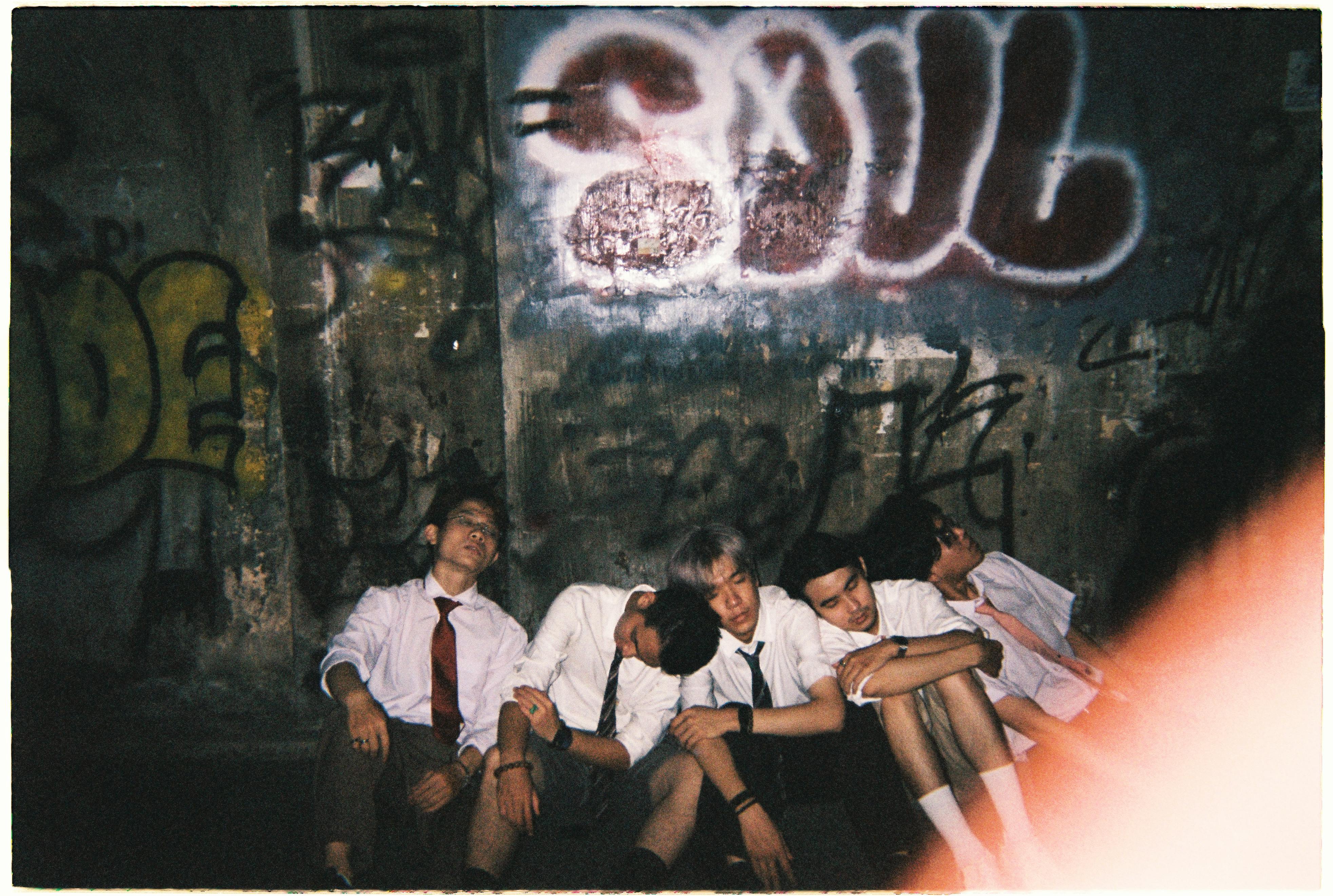Group of Teenagers Sleeping along Wall in Graffiti · Free Stock Photo