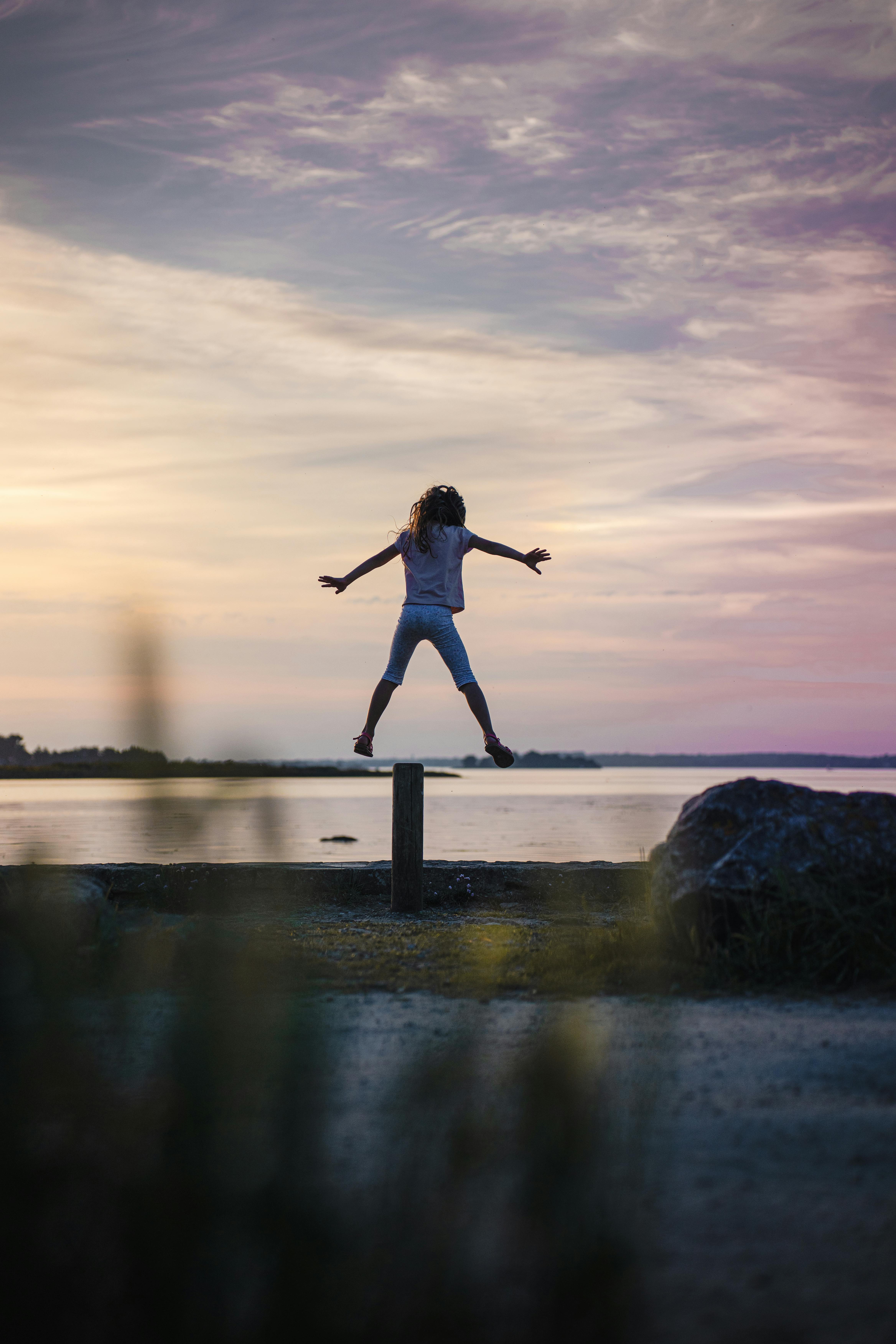 Man Jumping on Rocks Over a River · Free Stock Photo