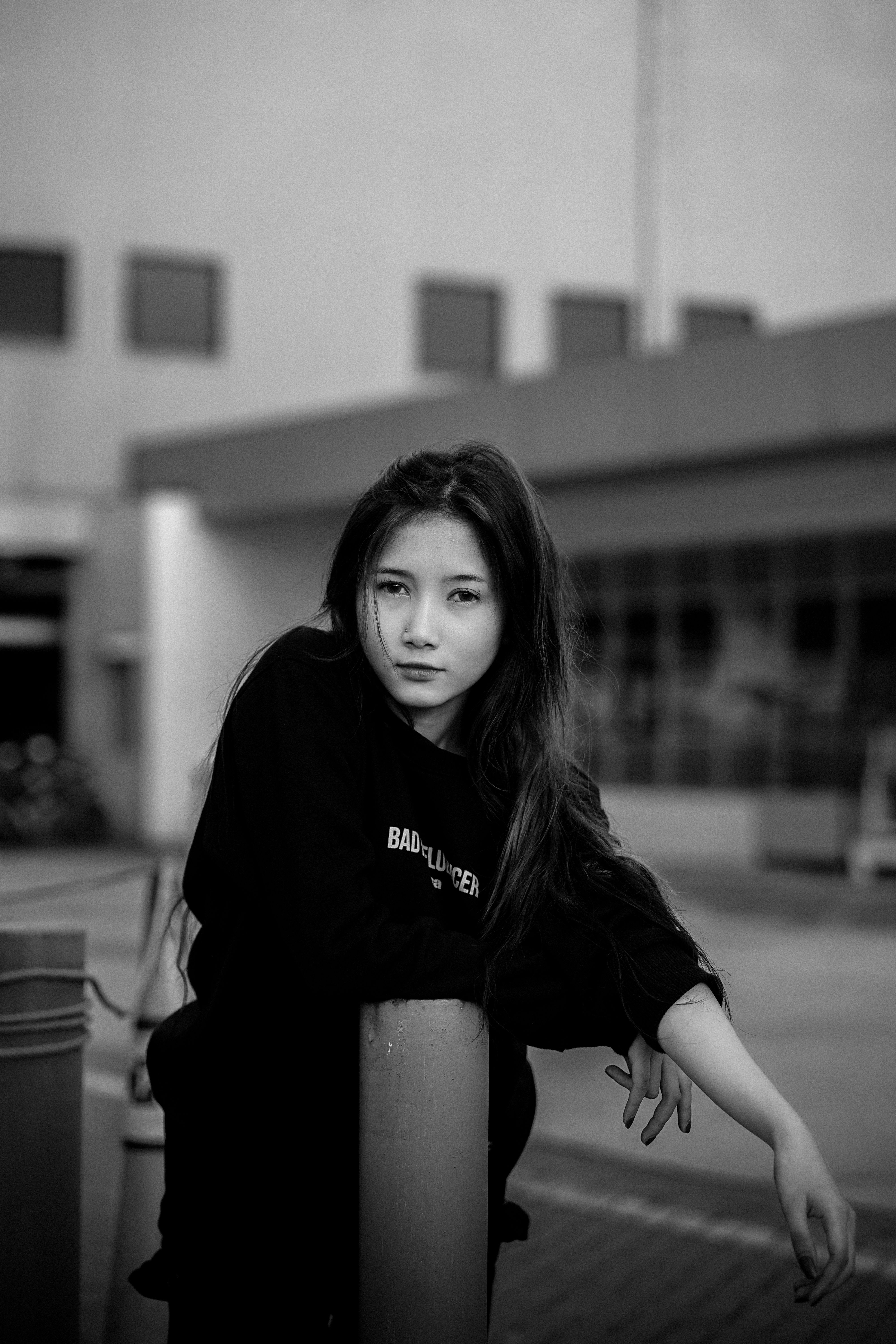 Woman Leaning on Post in Black and White · Free Stock Photo