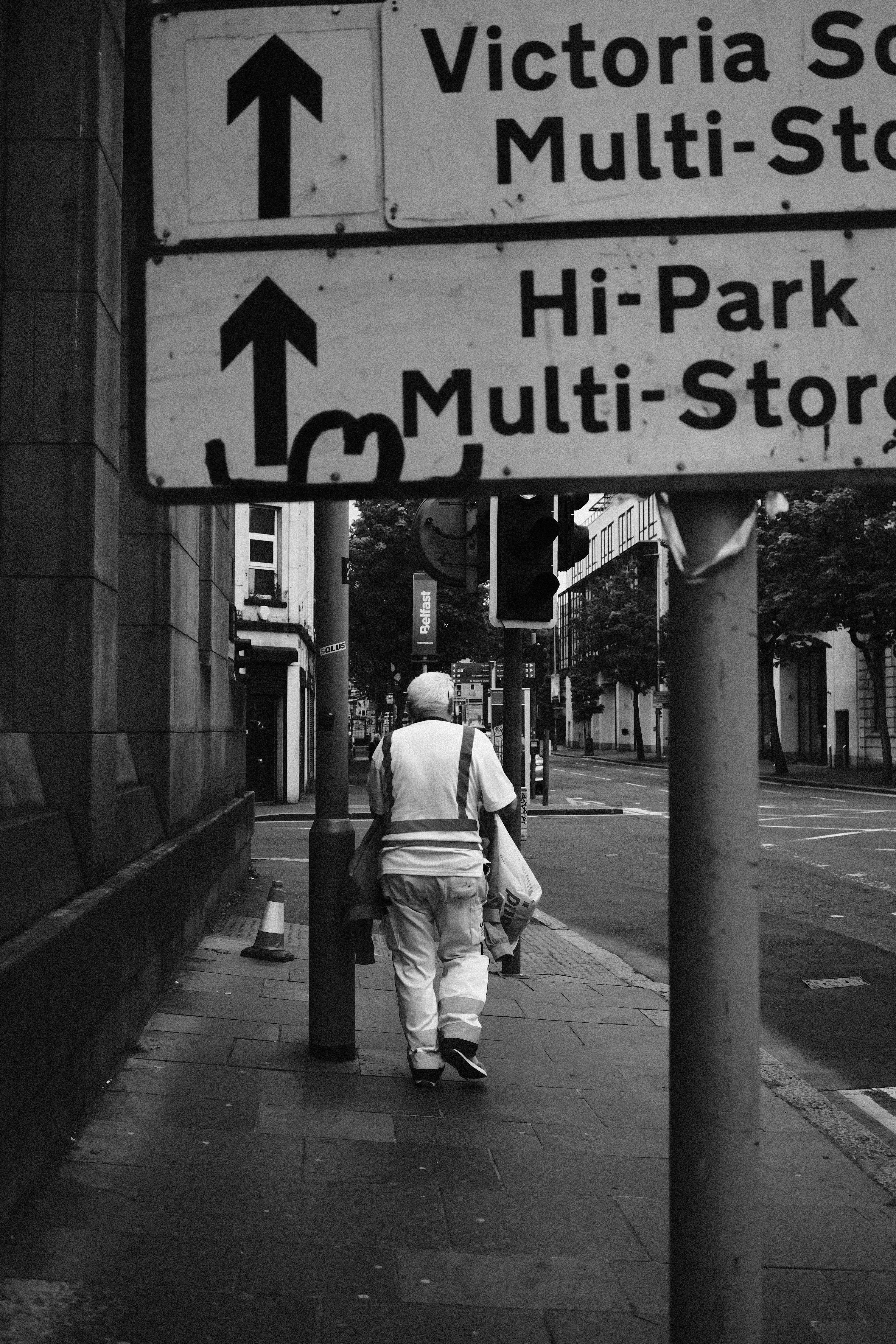 Photo of Man in a White Bathing Ape T-shirt Holding a Black Bag Walking ...