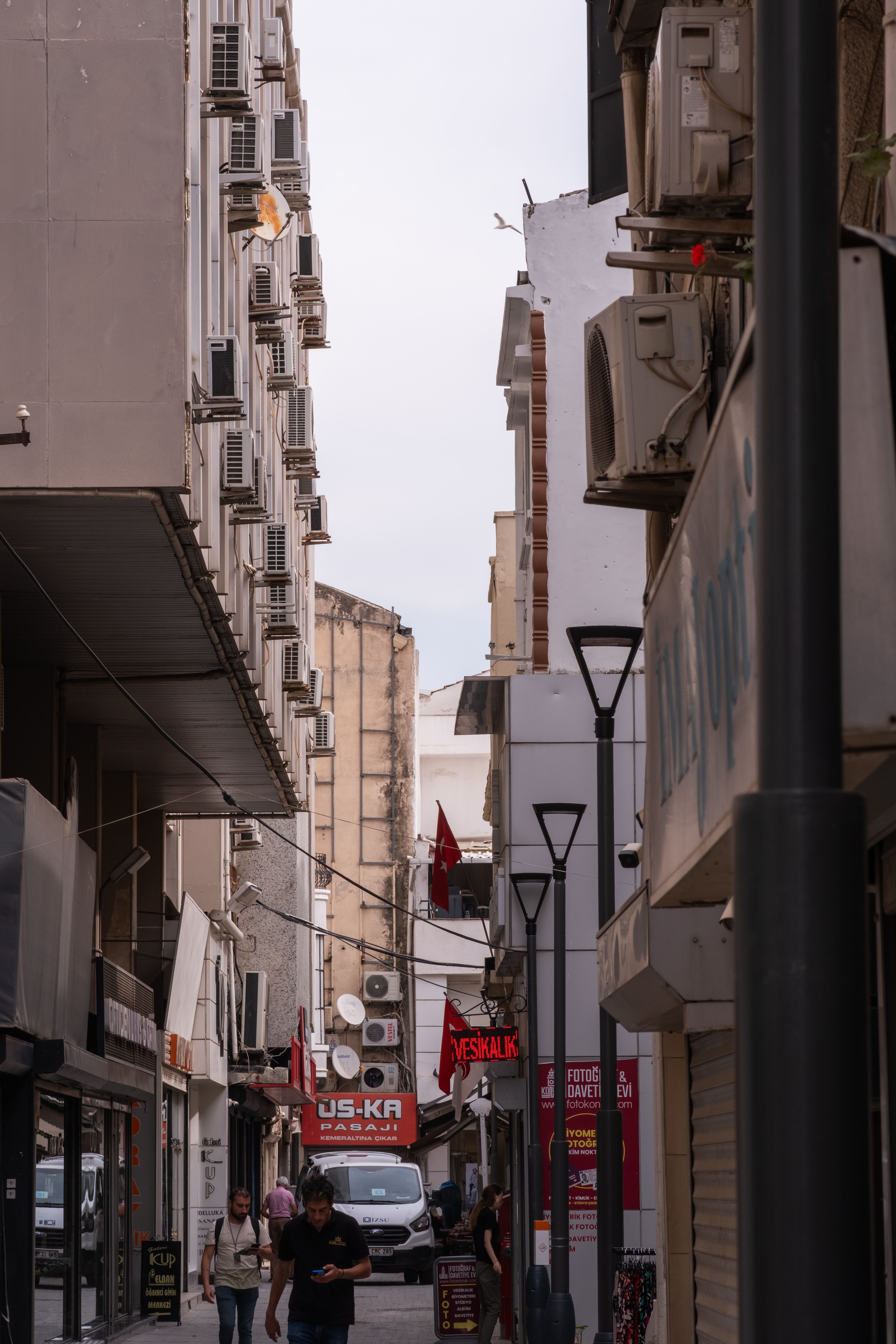 A narrow street with people walking down it · Free Stock Photo