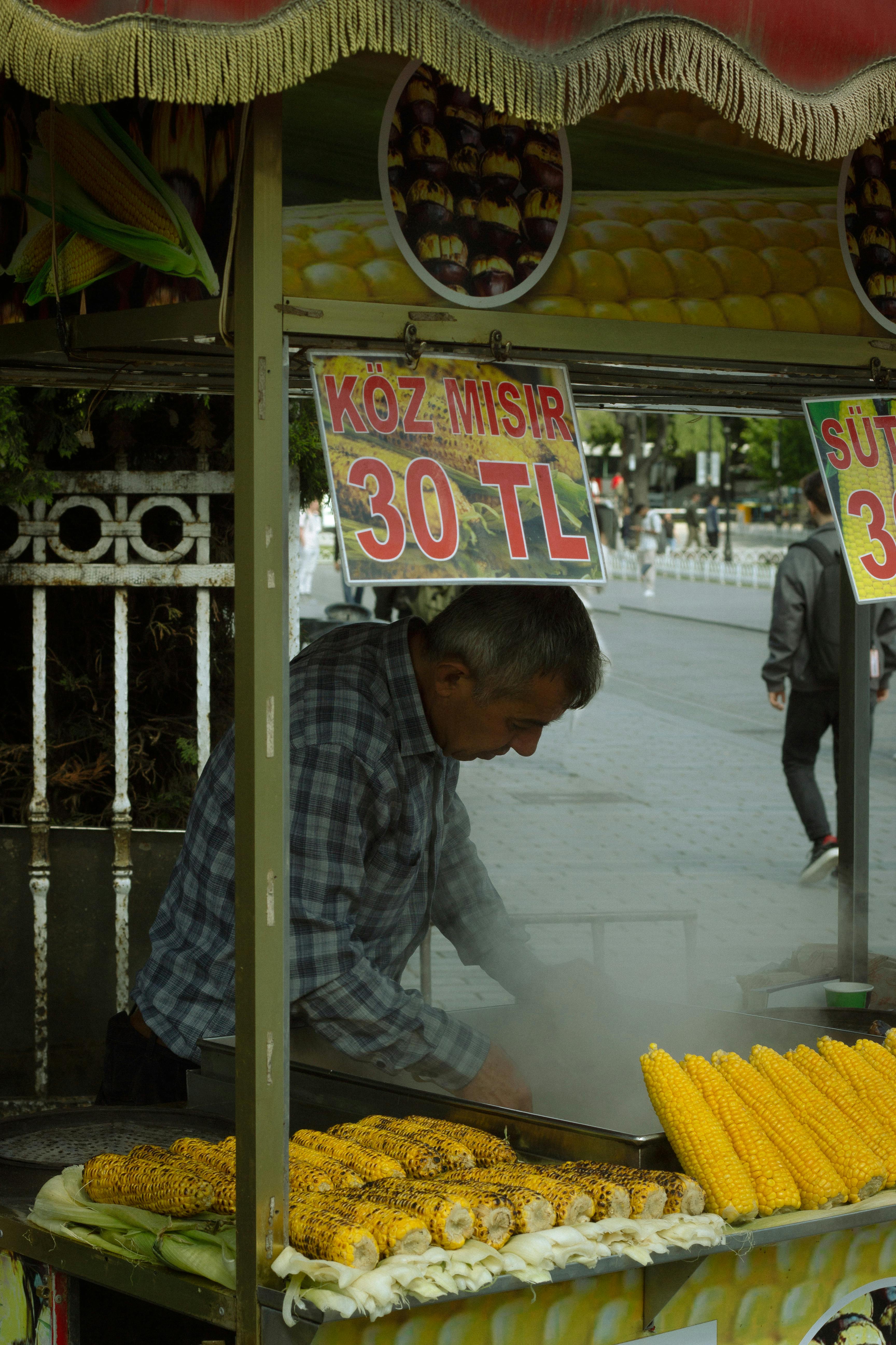 Man Selling Corn in a Booth · Free Stock Photo