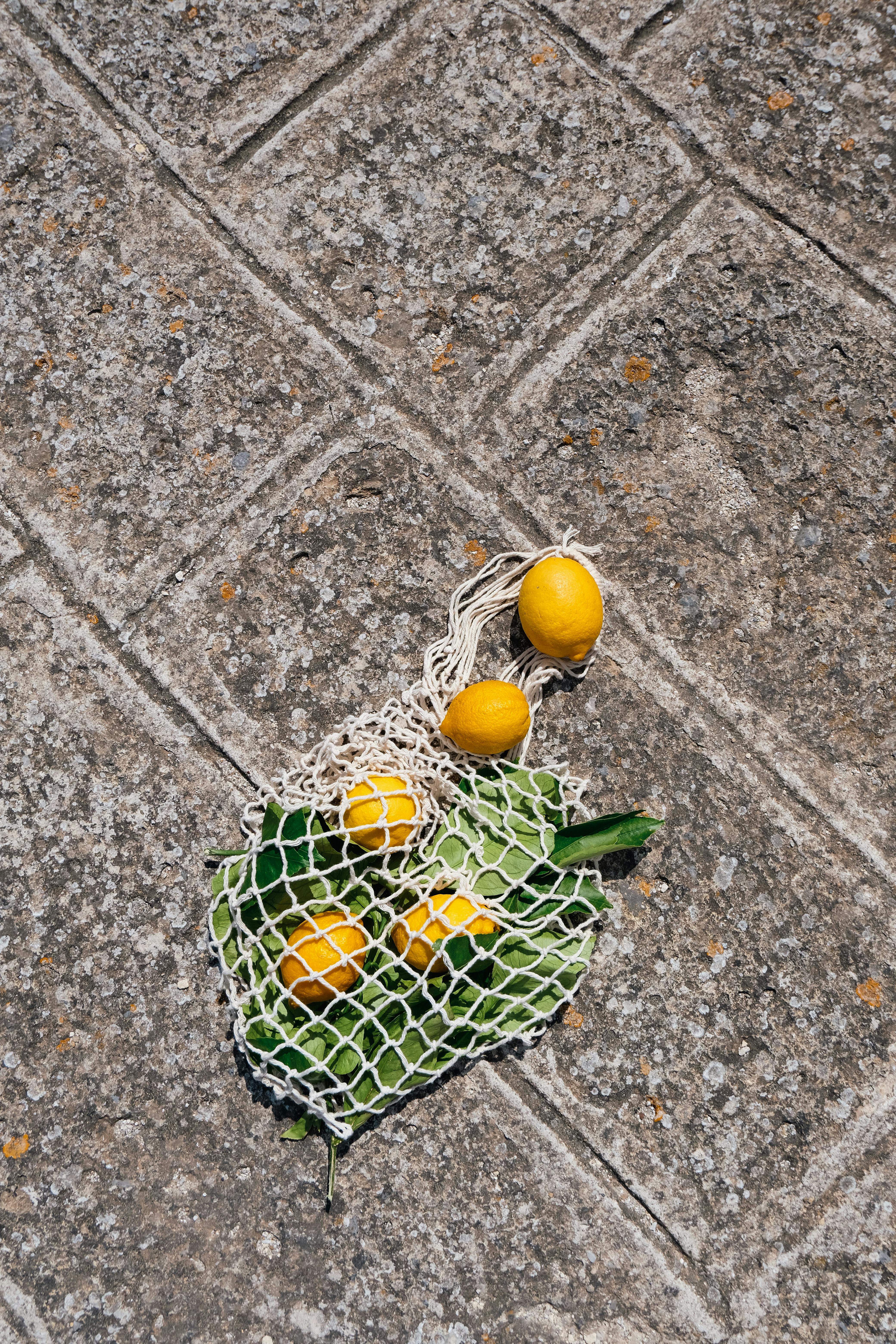 Torn Bag with Lemons on Pavement · Free Stock Photo