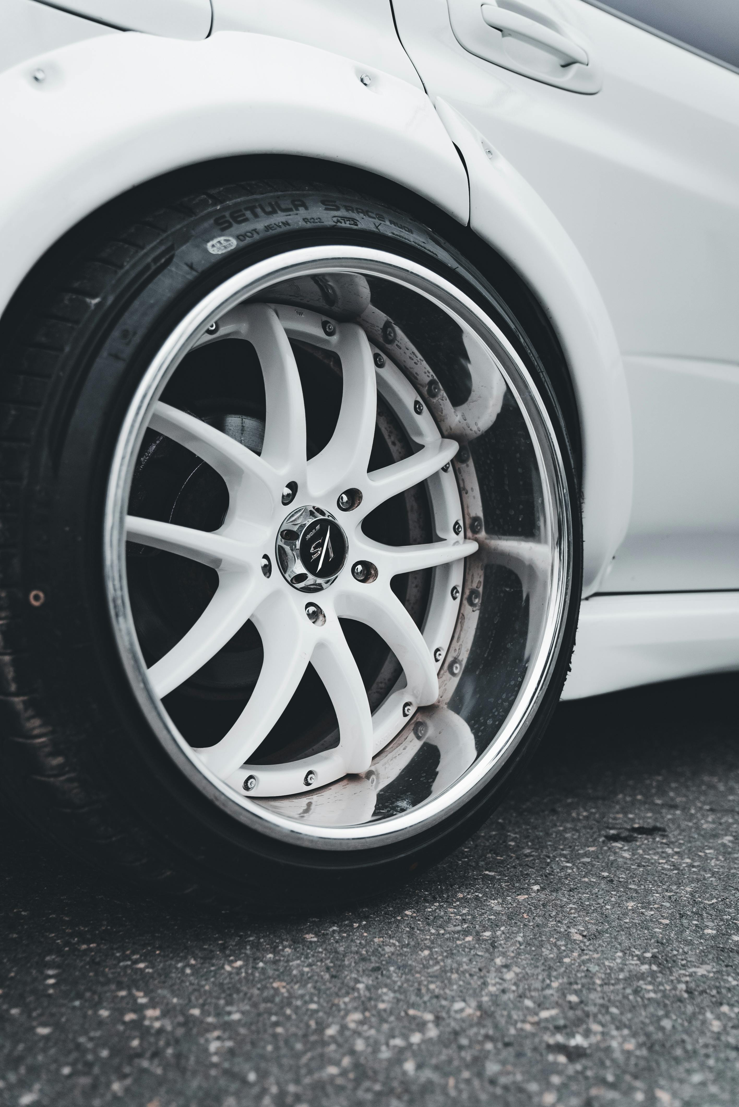 A white car with rims and tires on it · Free Stock Photo