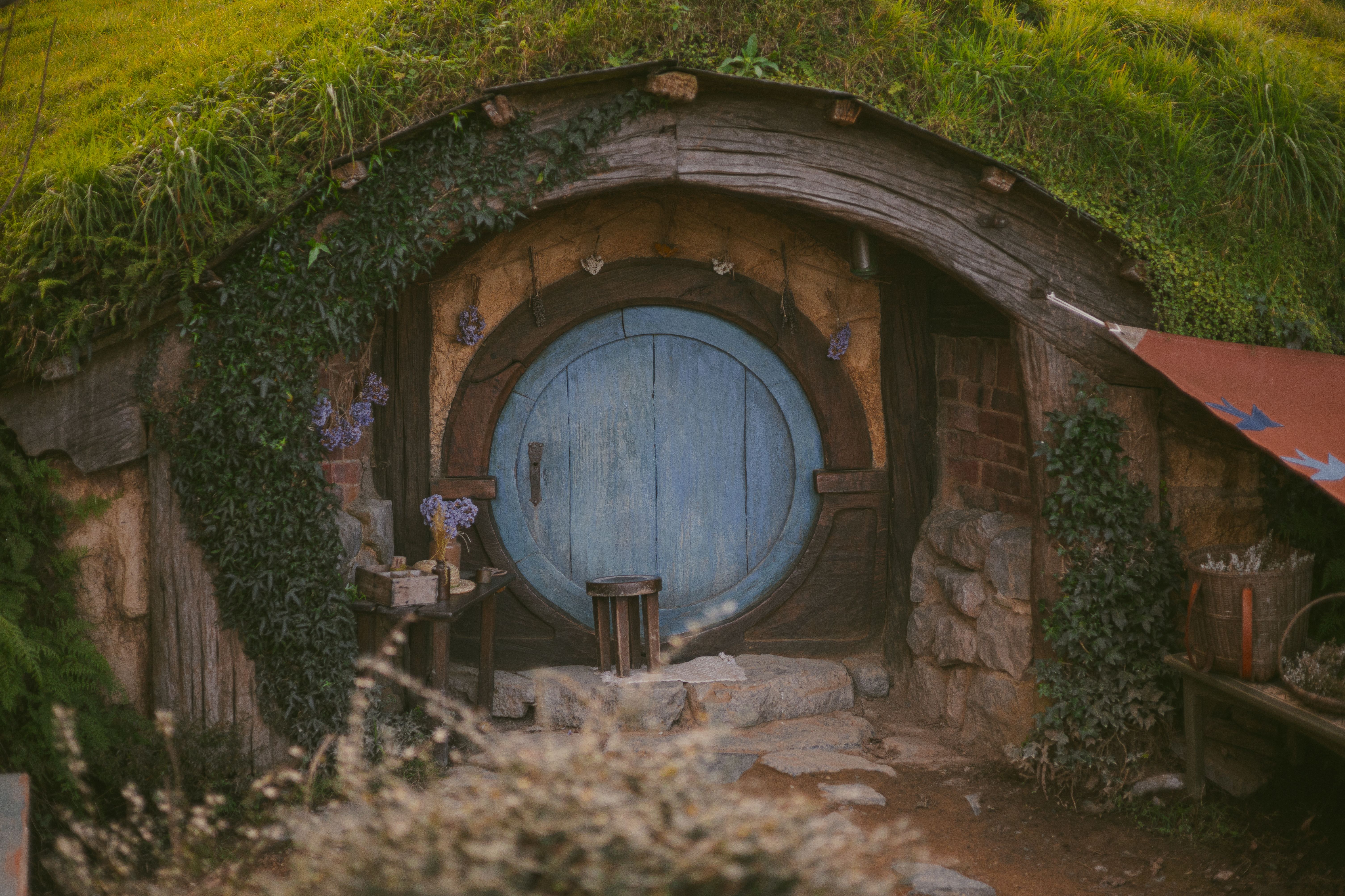 A hobbit house with a door and a green grassy area · Free Stock Photo