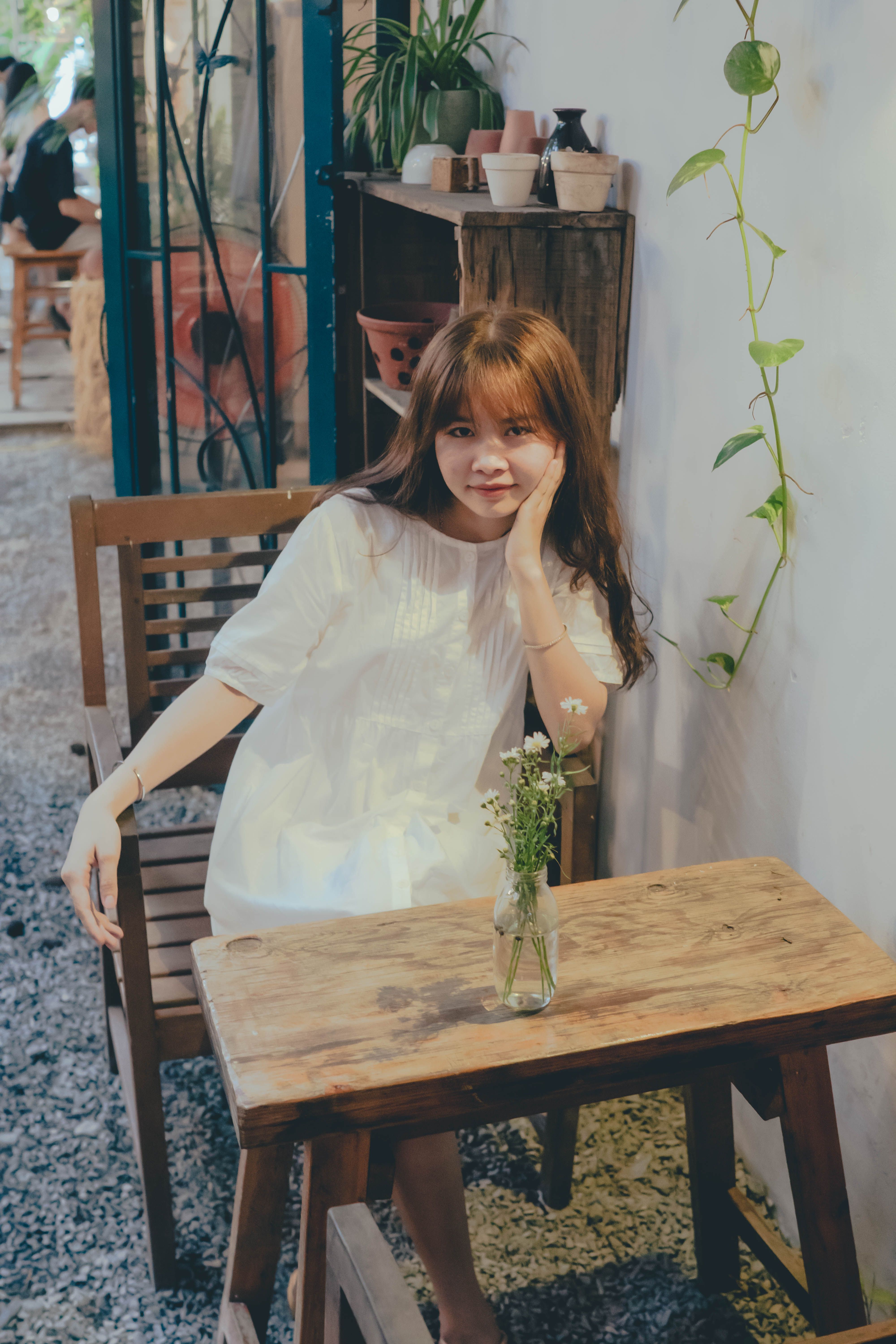 Woman in White Dress Sitting at Table at Cafe · Free Stock Photo