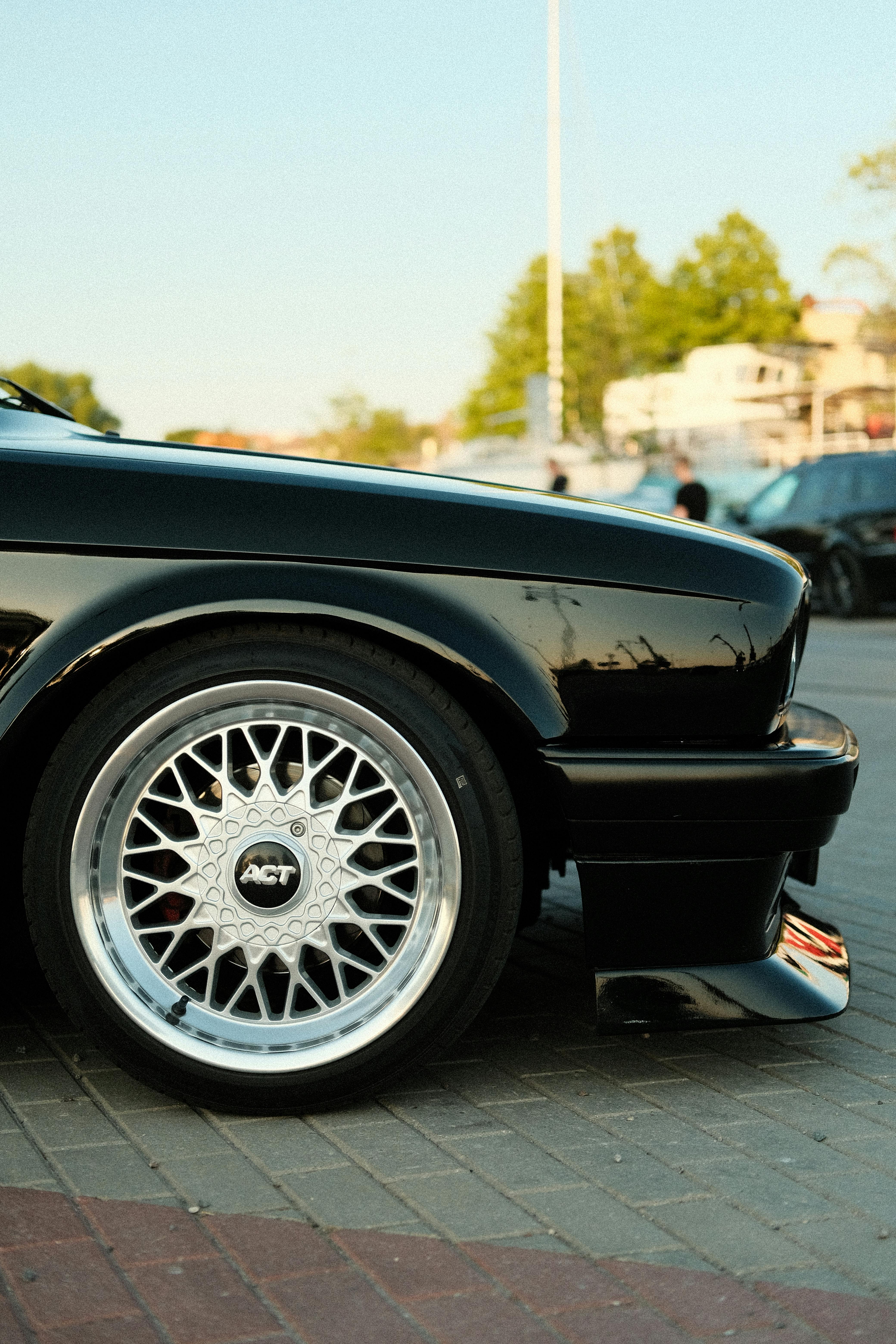 A black bmw car with rims on the street · Free Stock Photo