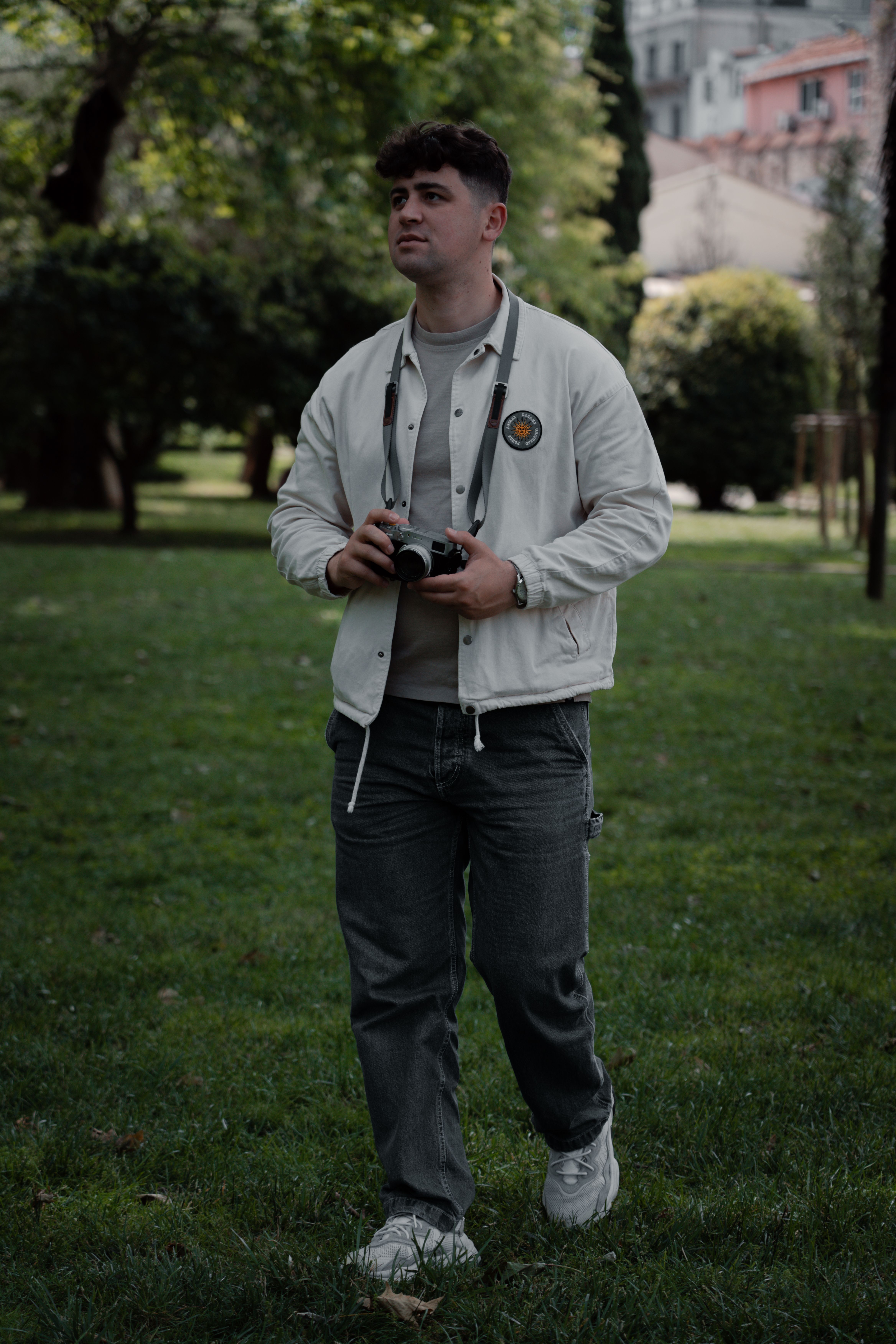 Man in Jacket Walking with Camera at Park · Free Stock Photo