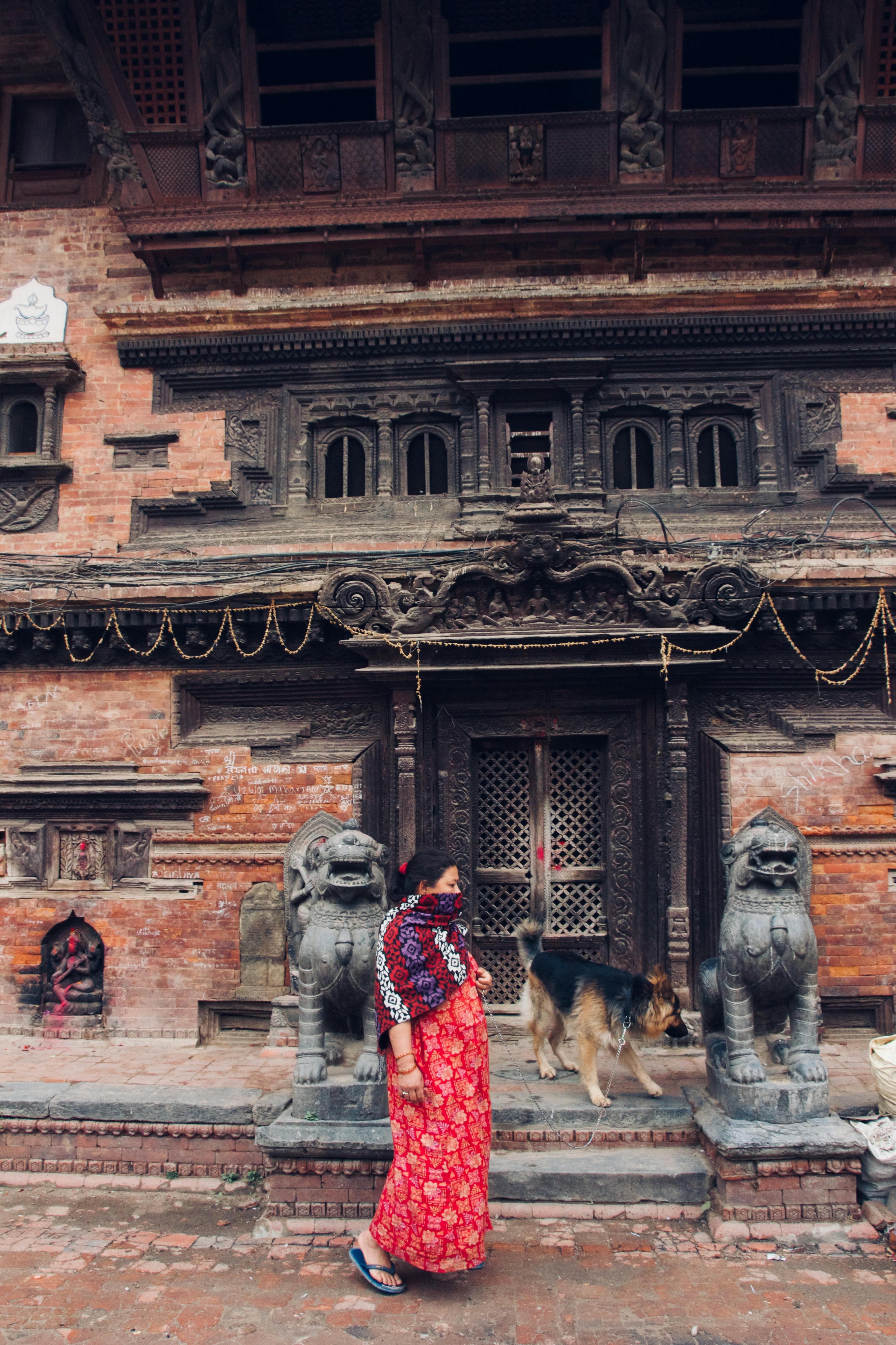 A lady walking a dog in ancient town of Patan, Nepal · Free Stock Photo