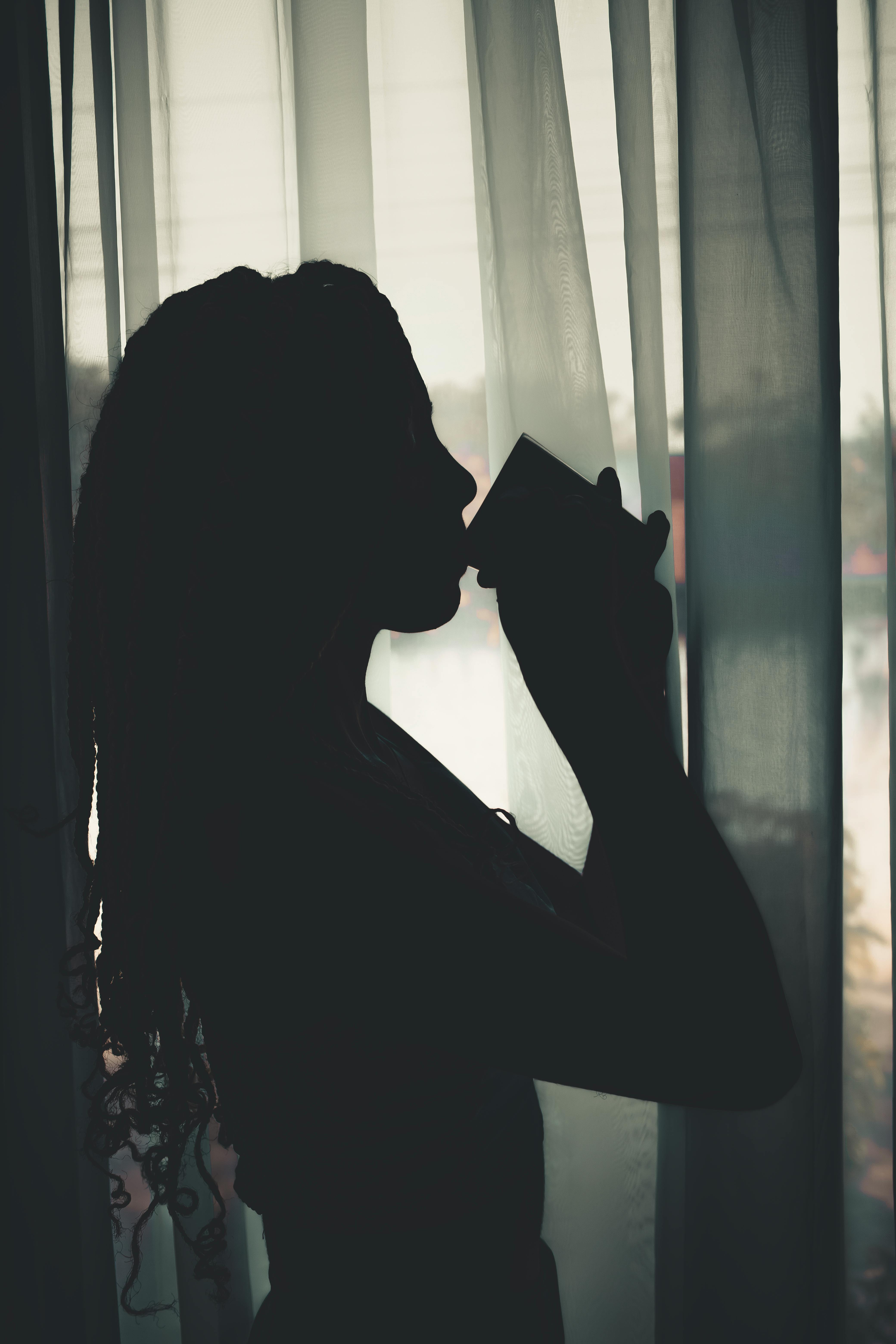 Silhouette of Woman Drinking from Mug · Free Stock Photo