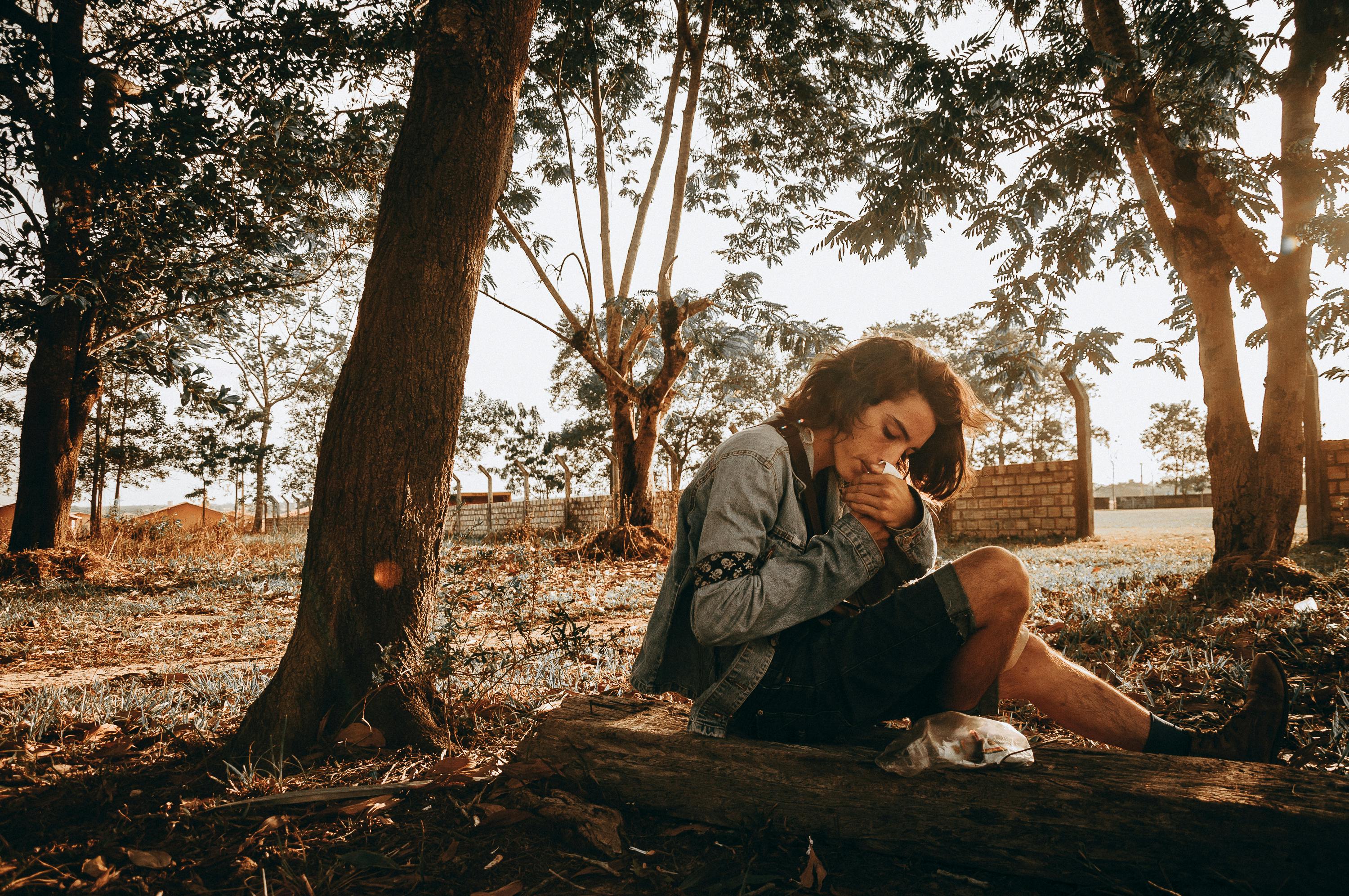 Persona Vestida Con Suéter Gris Sentado Sobre Troncos De Madera · Fotos ...