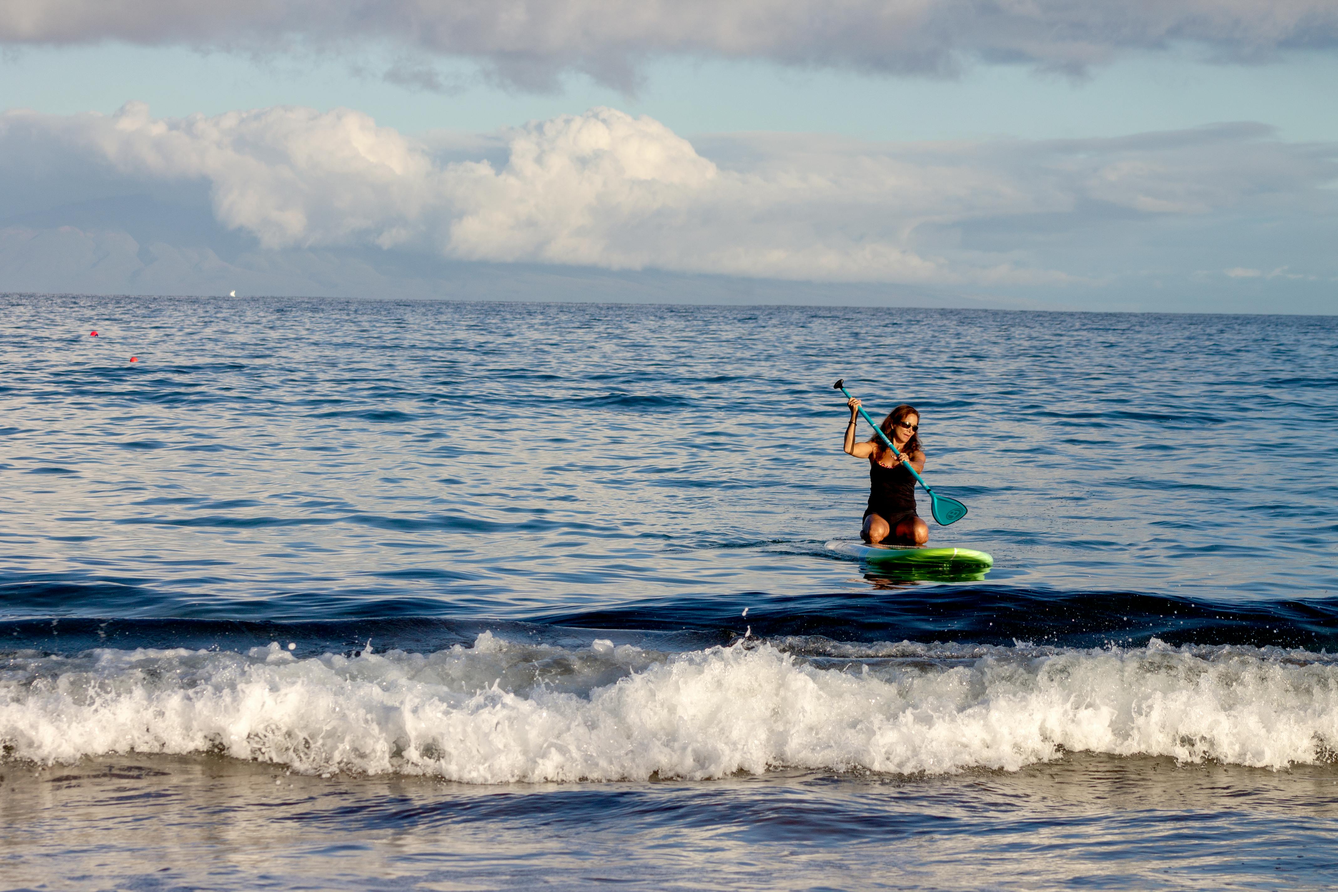 Woman Riding Green Surfboard Using Paddle · Free Stock Photo