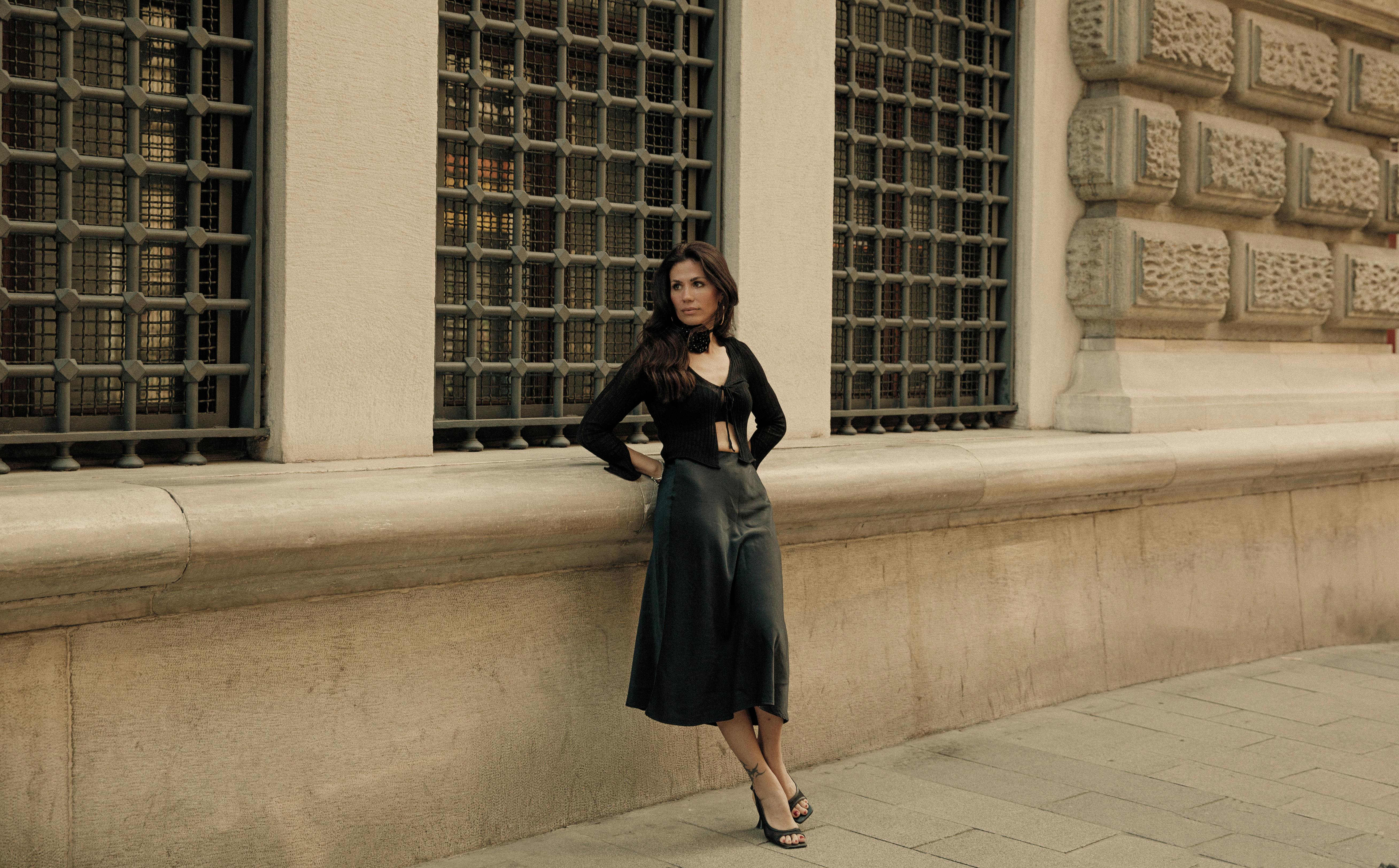 Elegant Woman Leaning against Building Wall · Free Stock Photo