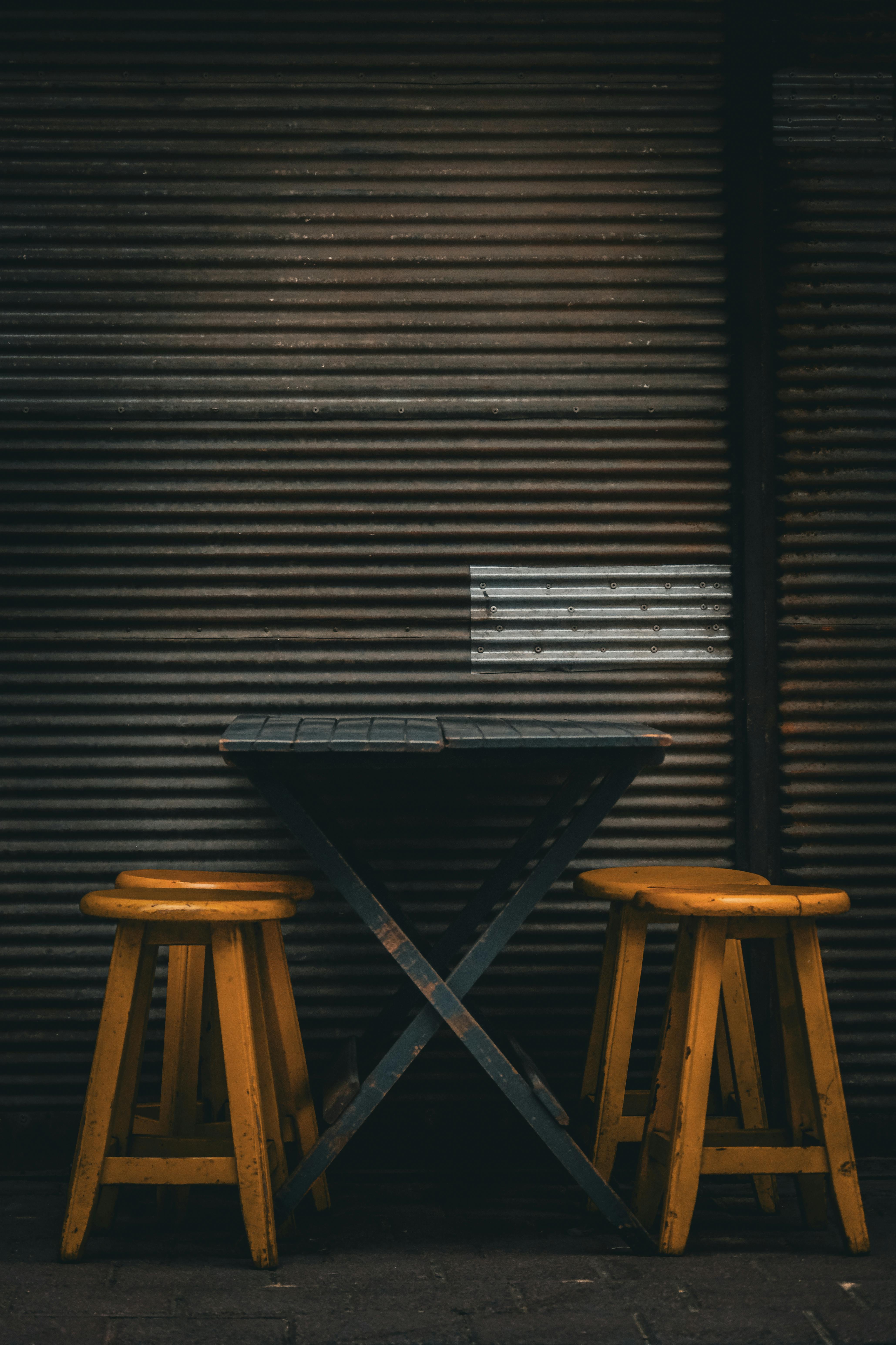 Restaurant Table Outside a Steel Shutter Door · Free Stock Photo