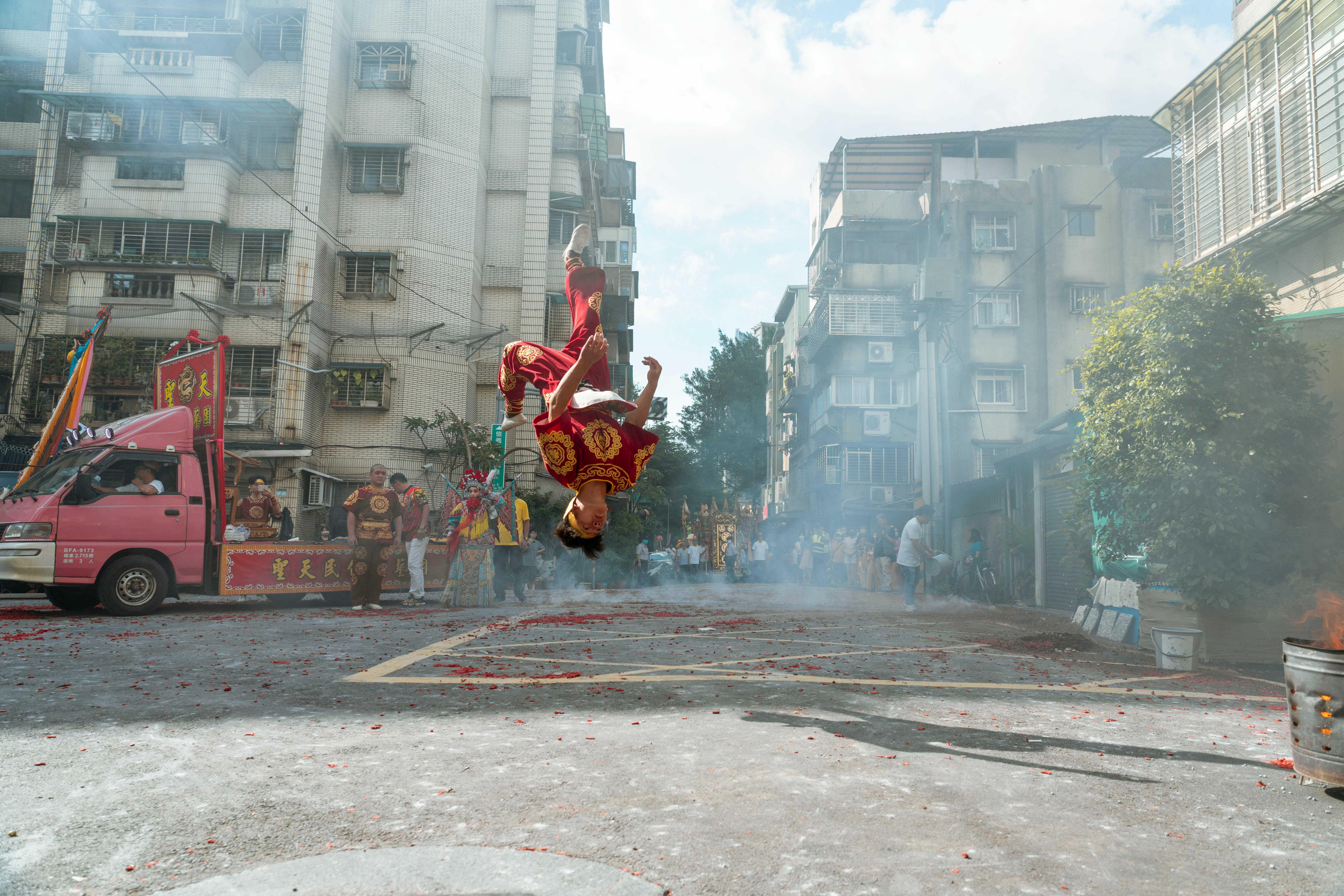 A Man in a Costume Doing a Flip · Free Stock Photo