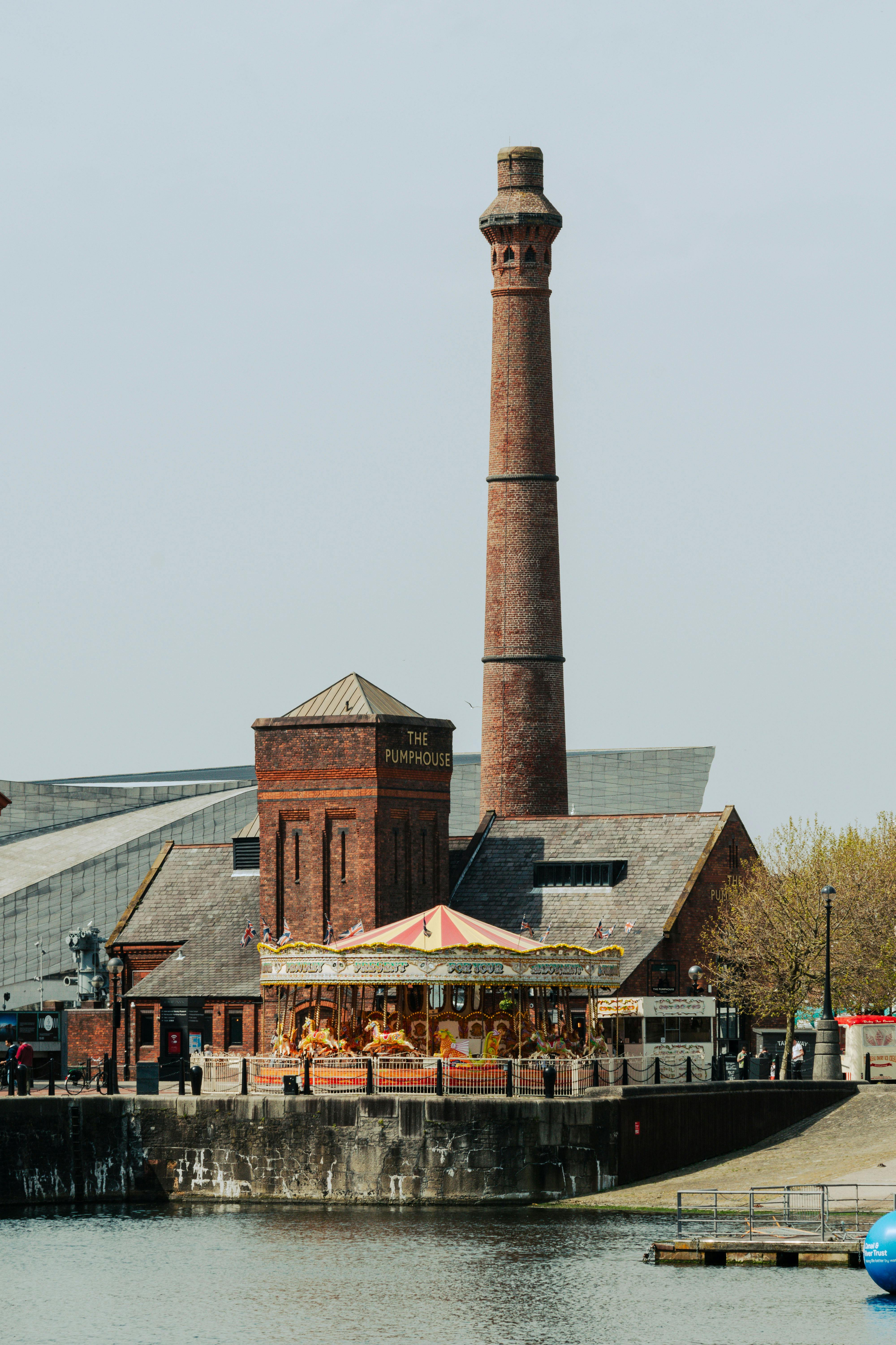A boat is docked next to a brick building · Free Stock Photo