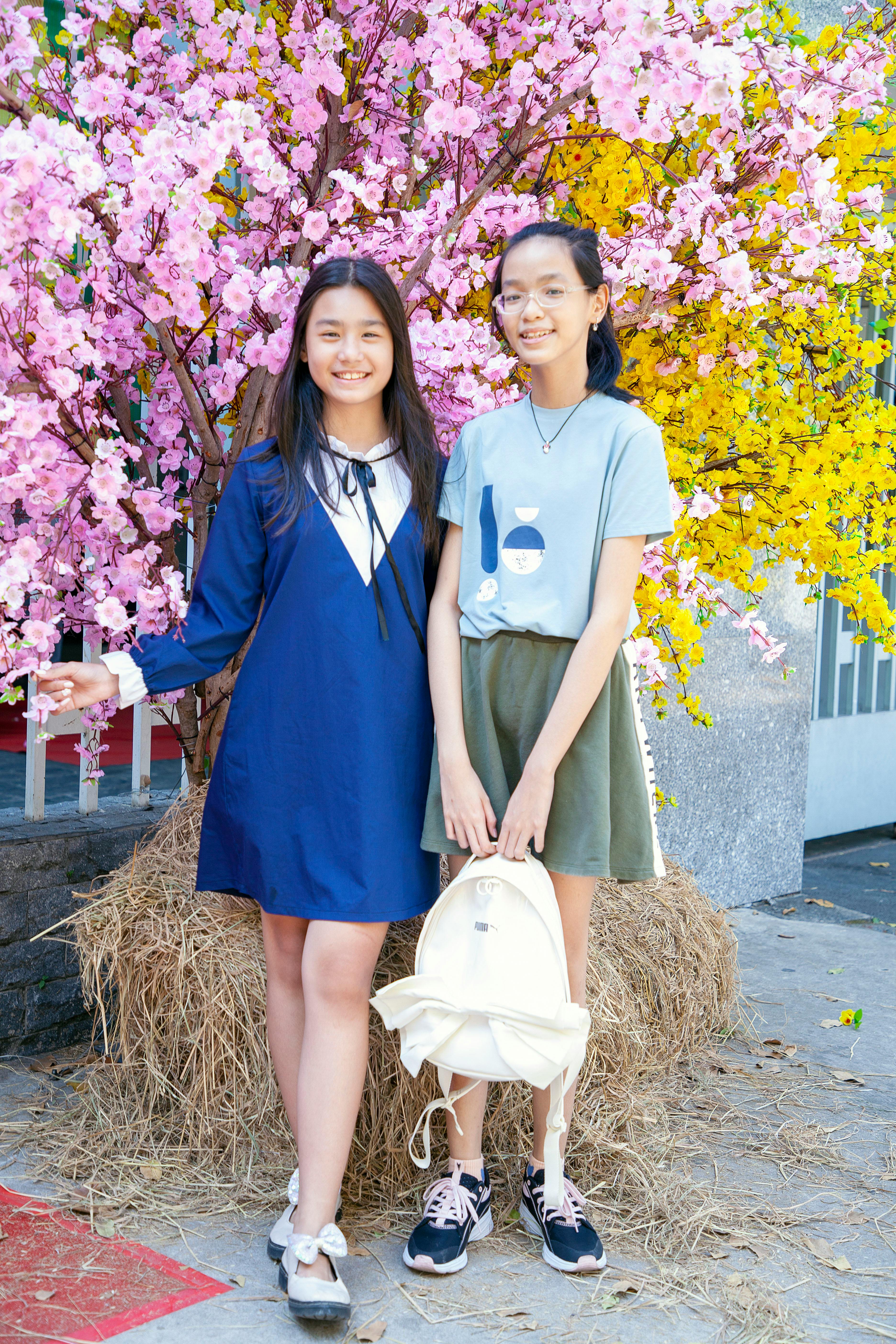 Happy Girls Standing Side by Side Next to Tree with Pink Flowers · Free ...