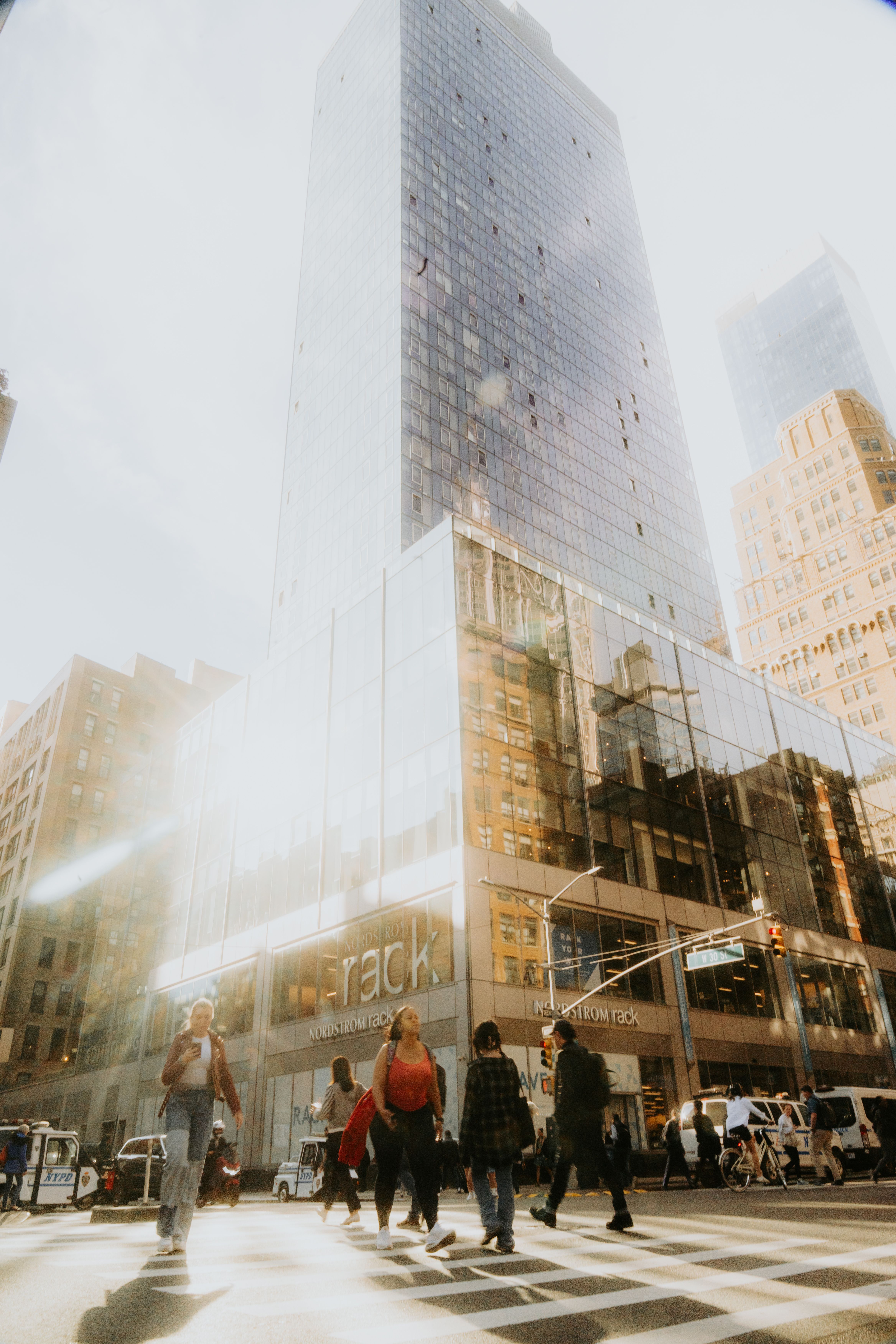 People walking across a street in front of a tall building · Free Stock ...