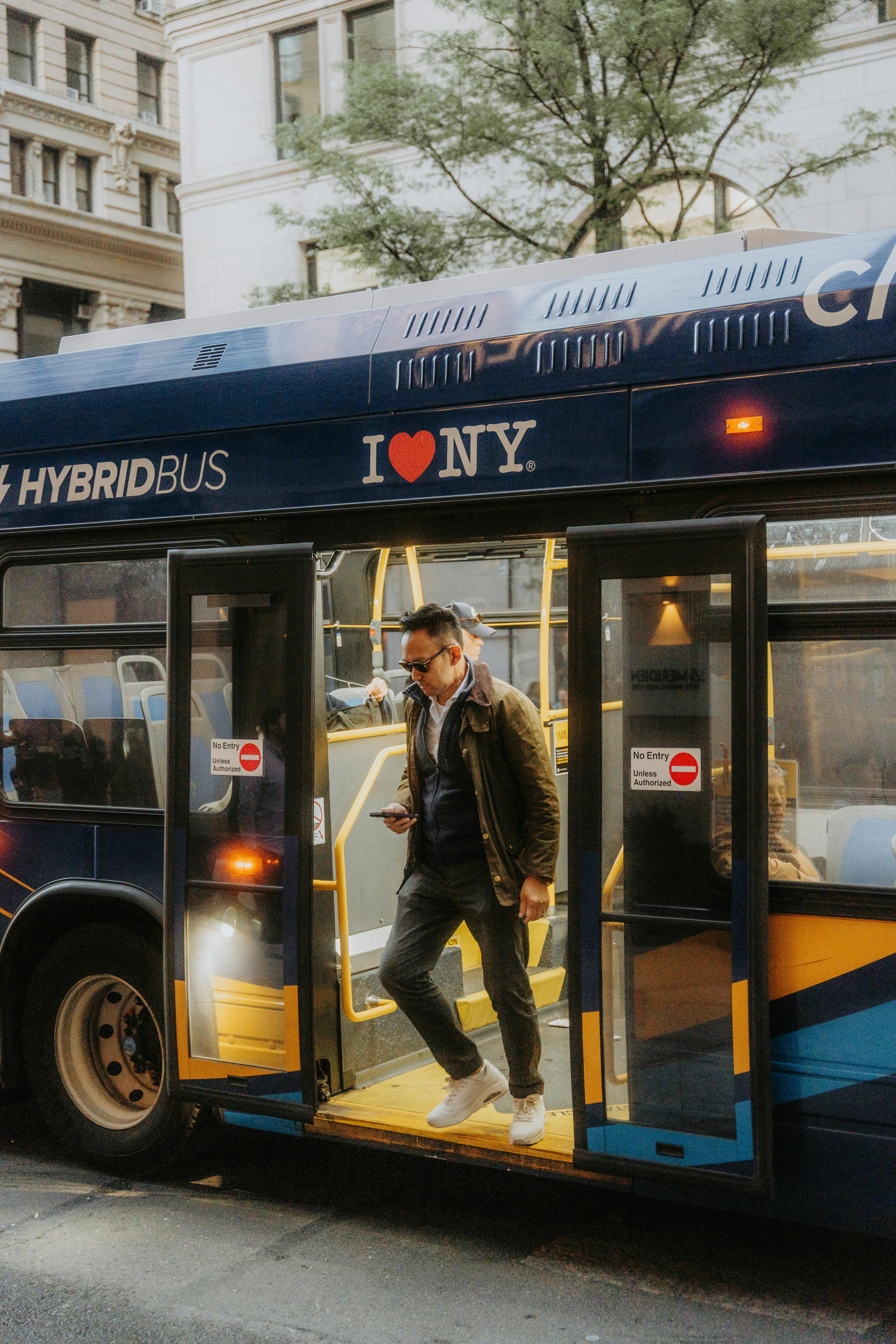 A Man Disembarking a Bus in New York City, NY, USA · Free Stock Photo