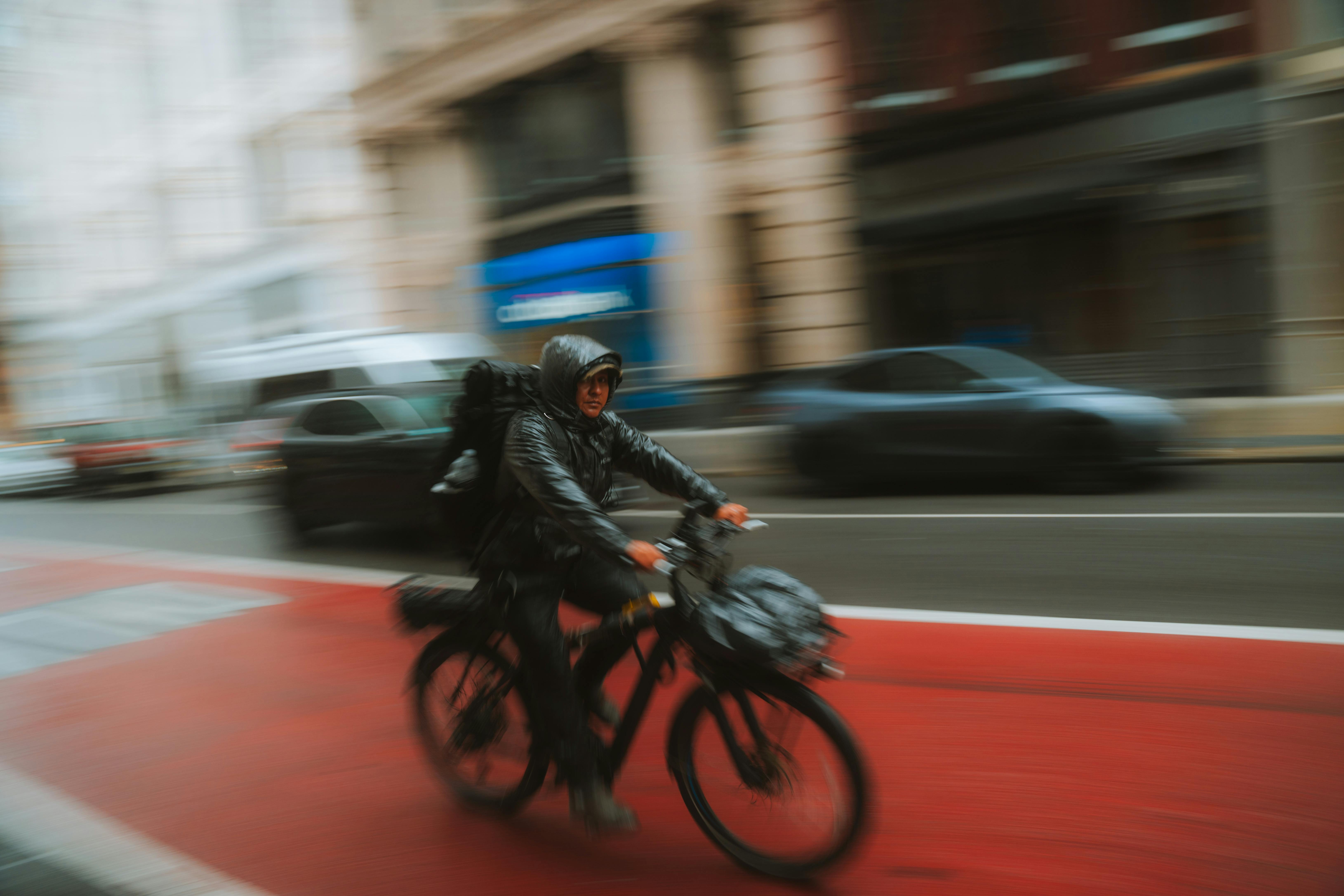 Man Riding Bicycle on Street in Rain · Free Stock Photo