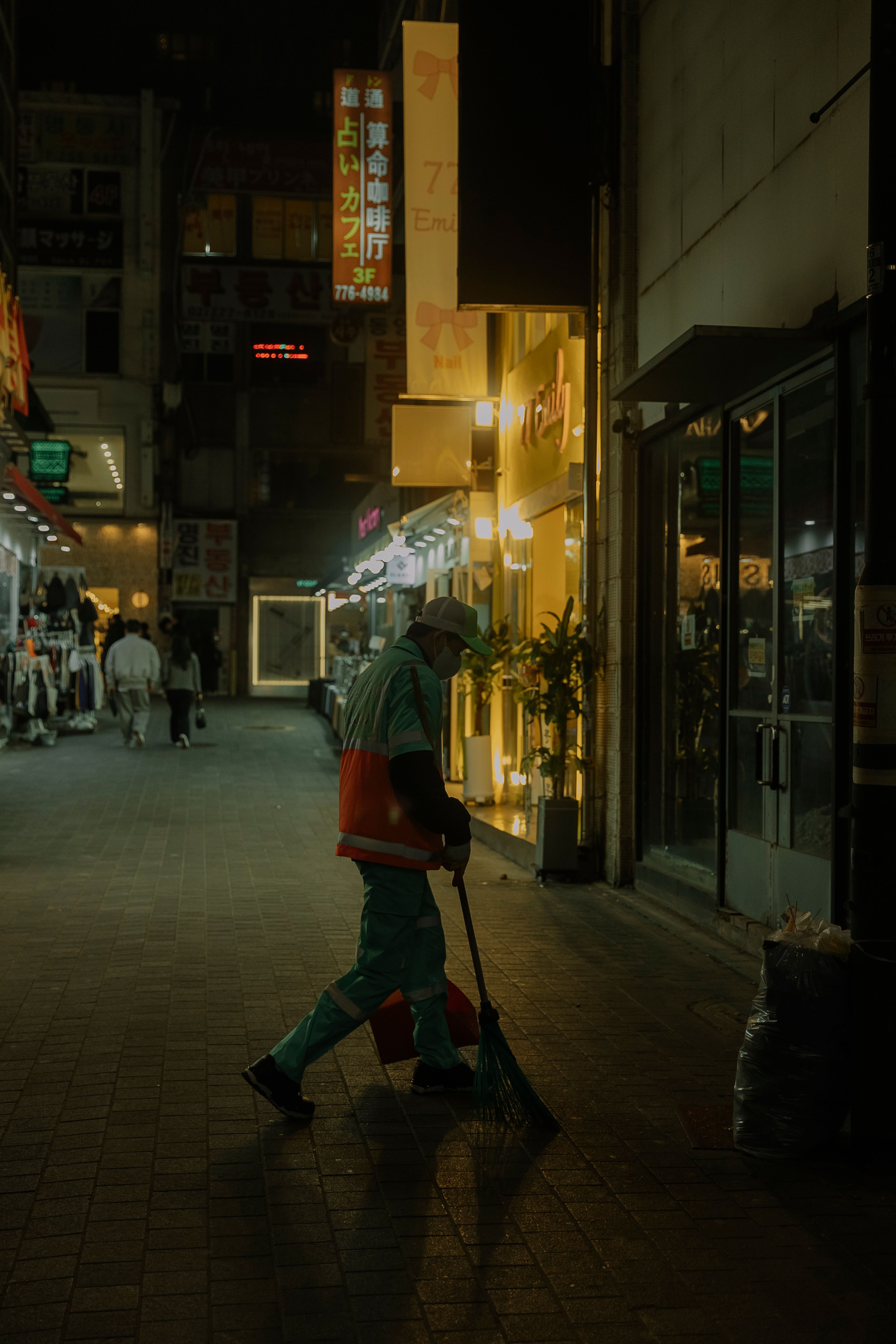 Man Sweeping Sidewalk in City at night · Free Stock Photo